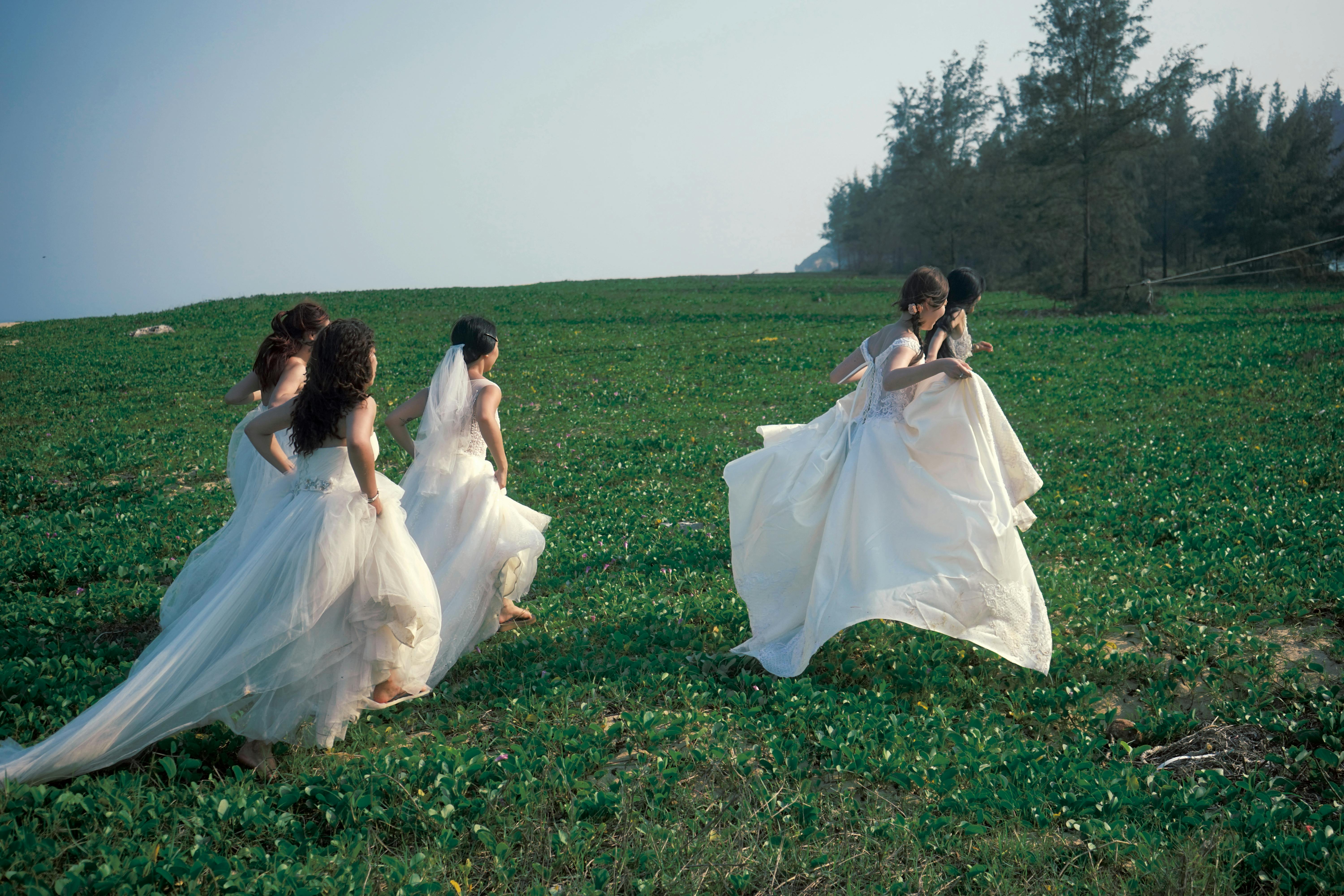 Brides in White Dresses Running in Field · Free Stock Photo