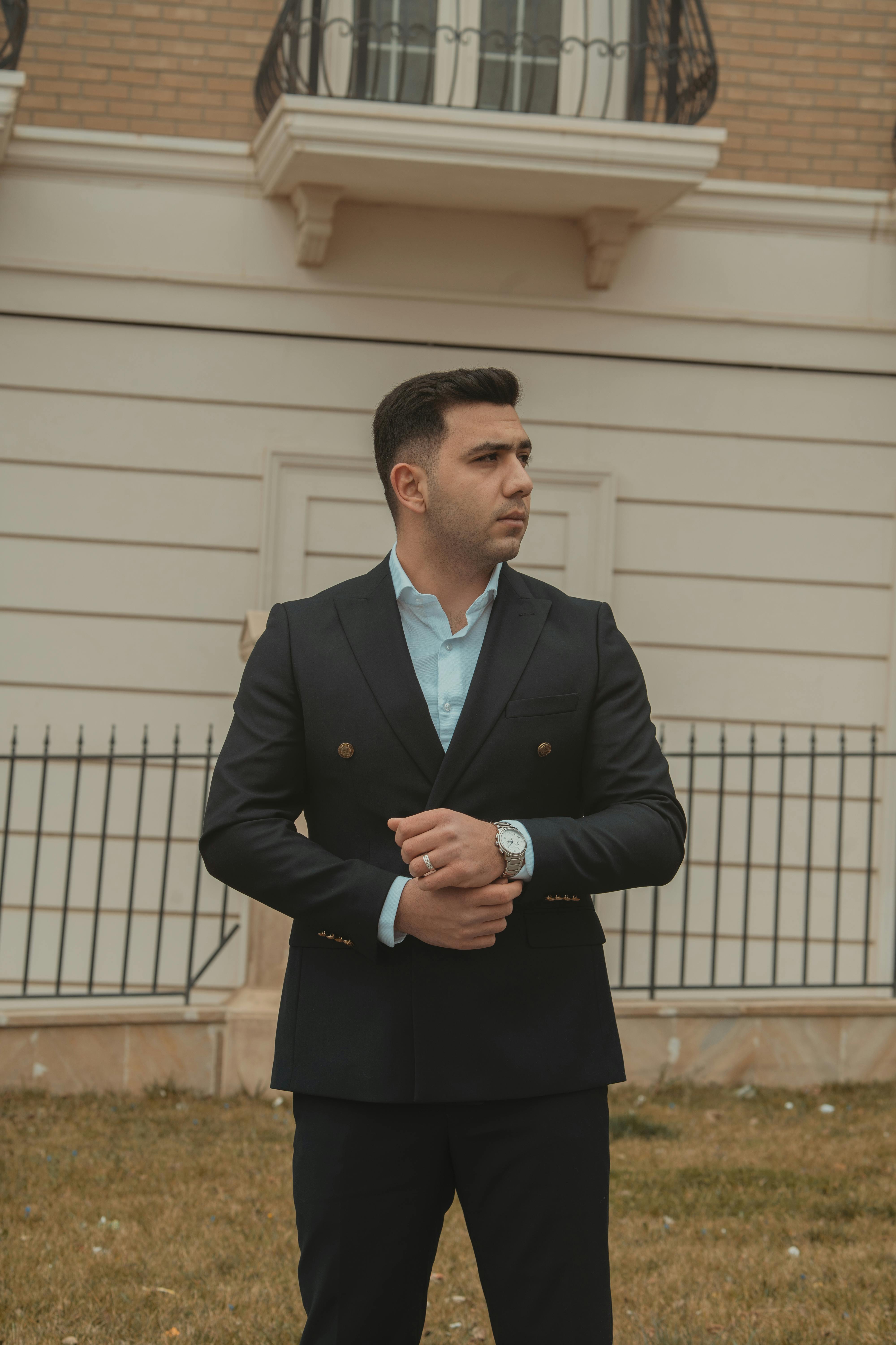 Man Wearing a Suit and a Wristwatch, Posing against a Building Facade ...