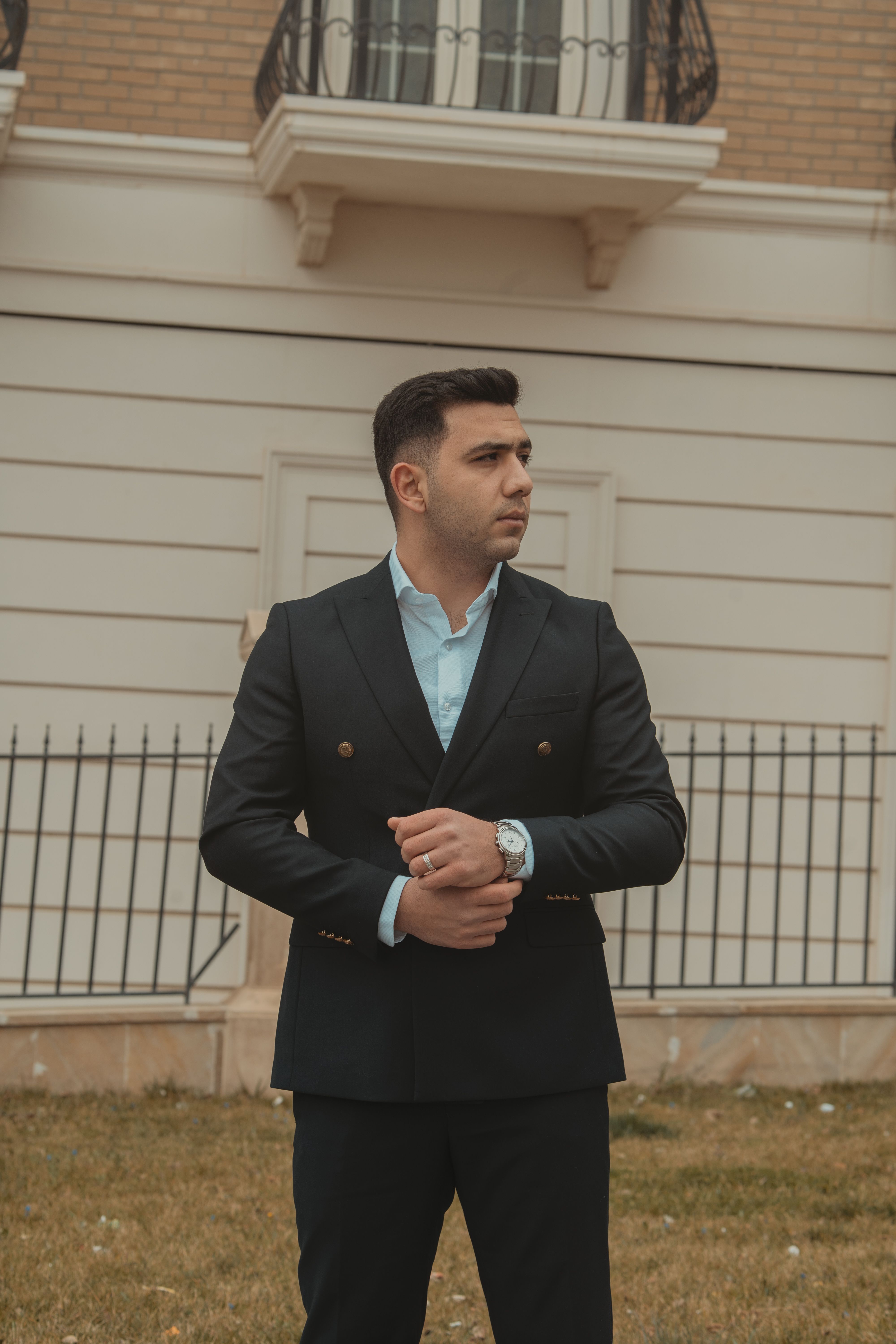 Man Wearing a Suit and a Wristwatch, Posing against a Building Facade ...