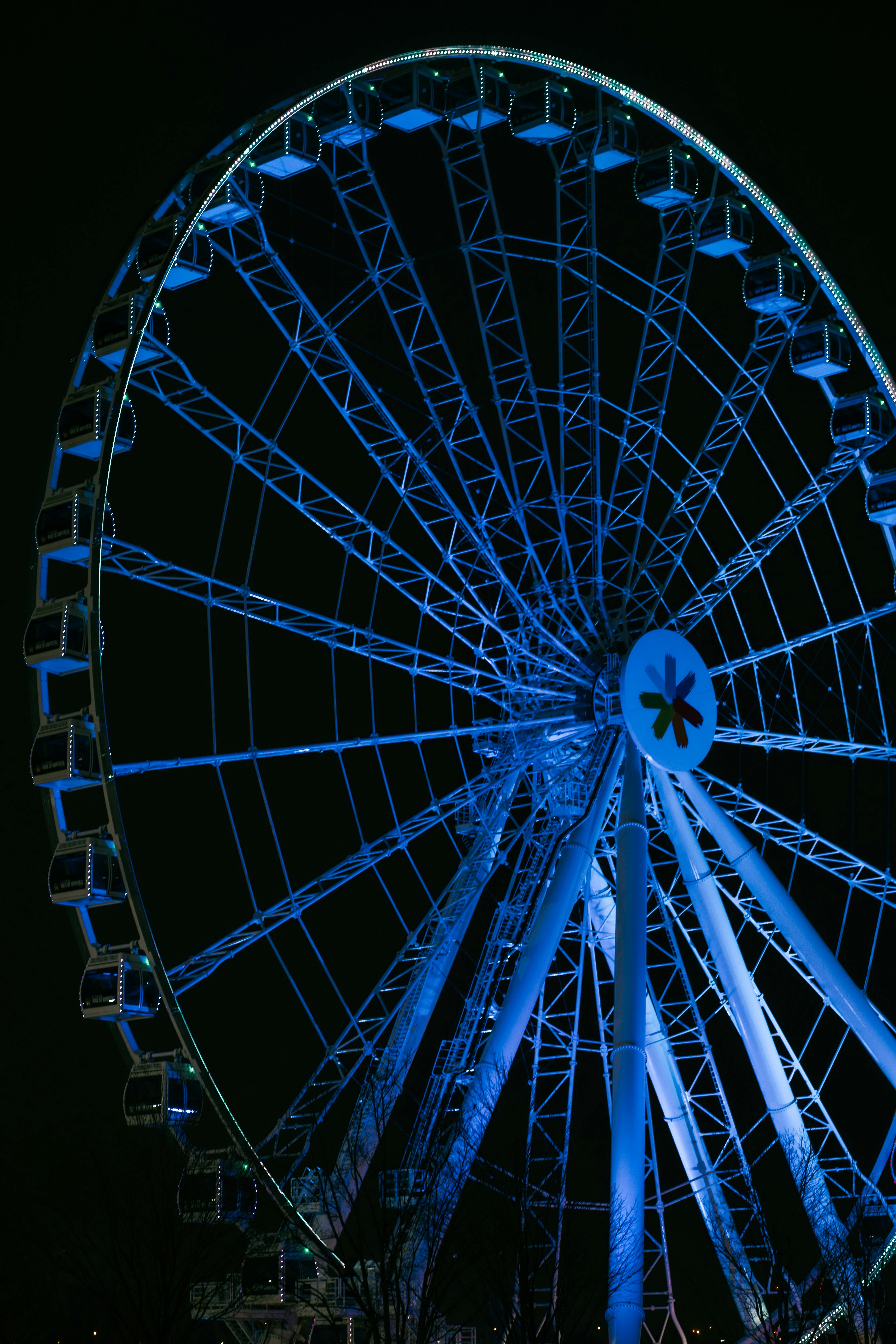 A large ferris wheel is lit up in blue · Free Stock Photo