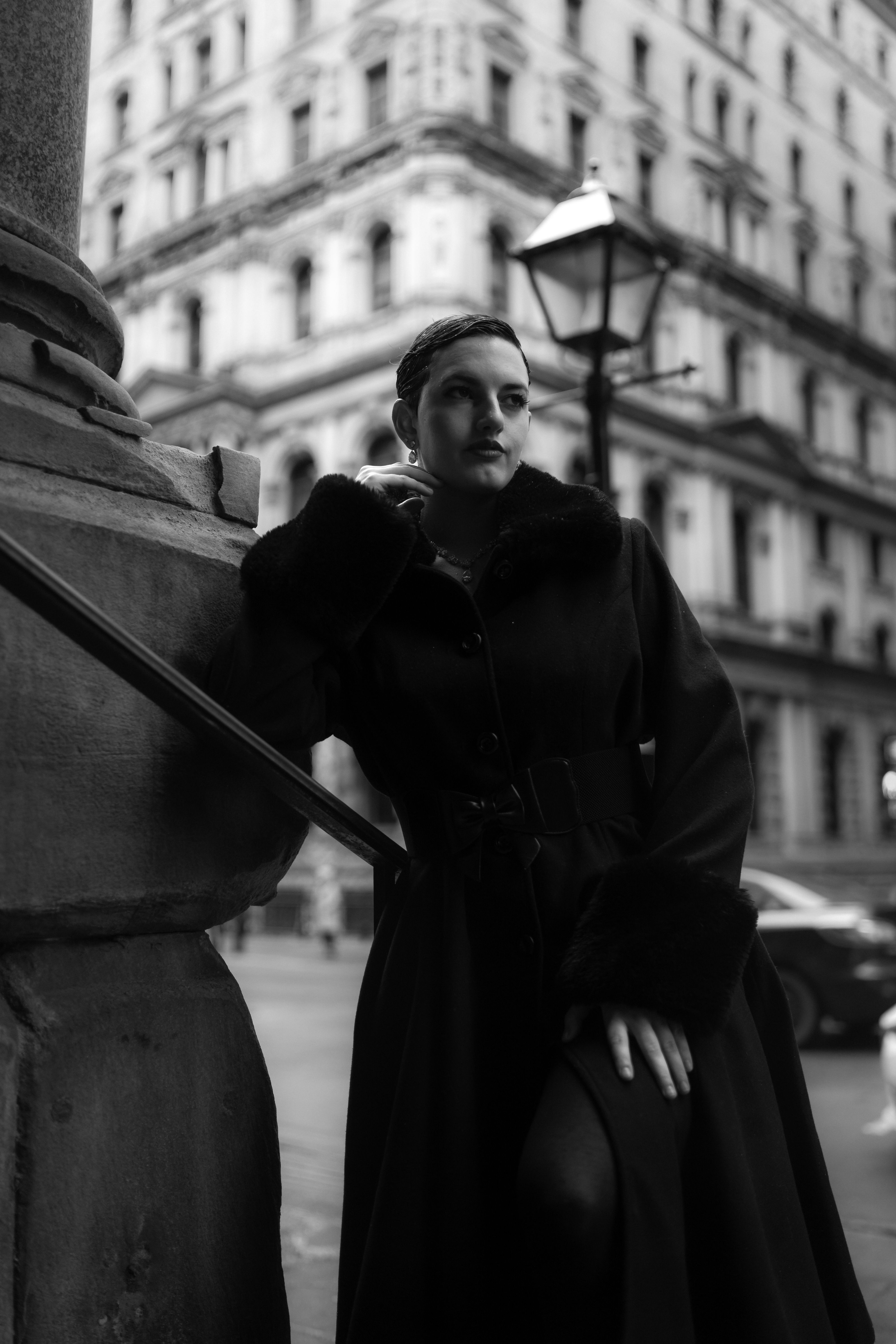 Black and white photo of woman leaning against building · Free Stock Photo