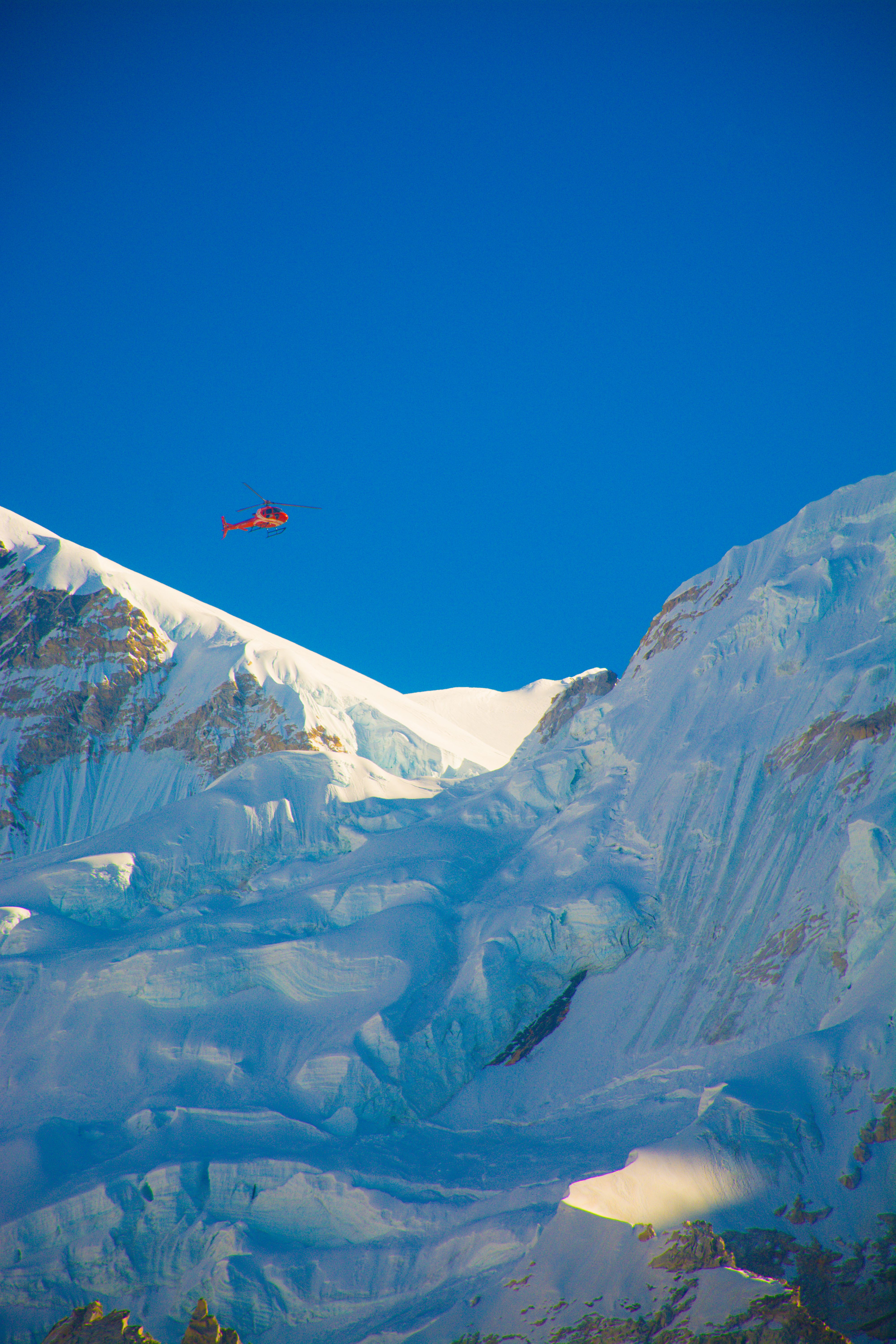 Helicopter Flying above Snow Covered Mountains against Blue Sky · Free ...