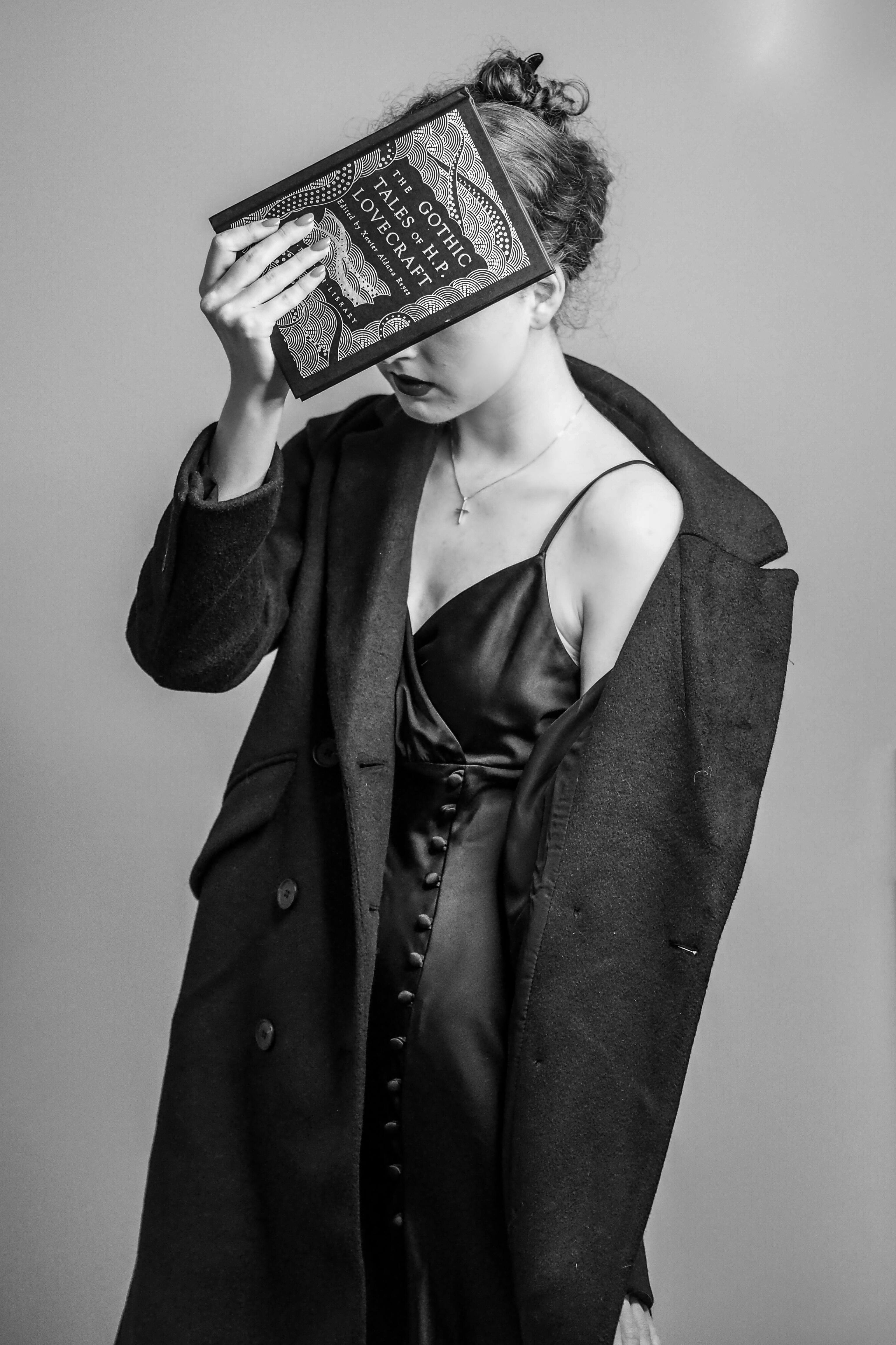 Woman Standing and Holding Book in Coat and Dress · Free Stock Photo