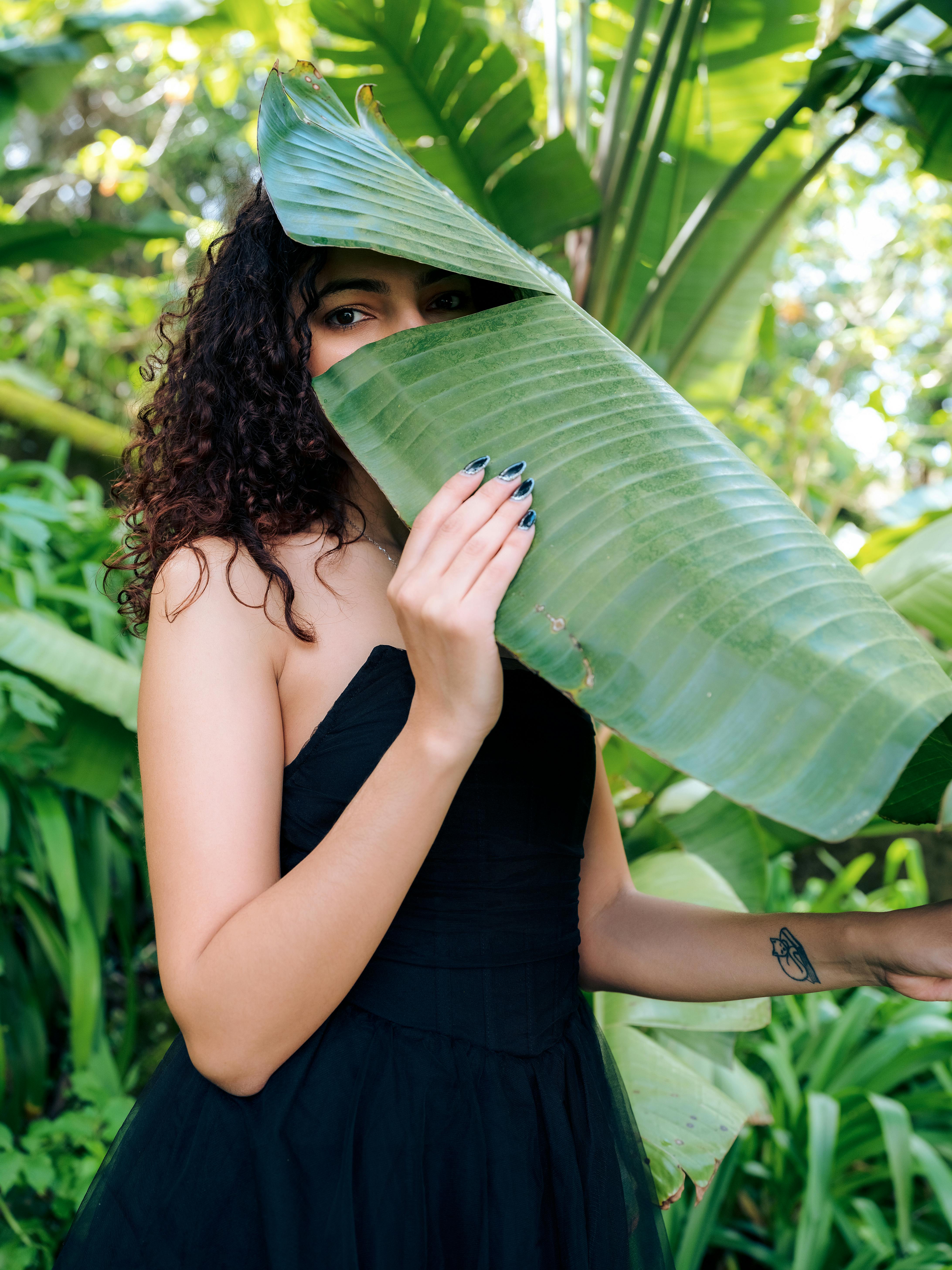 Female Model Hiding behind a Large Green Leaf · Free Stock Photo