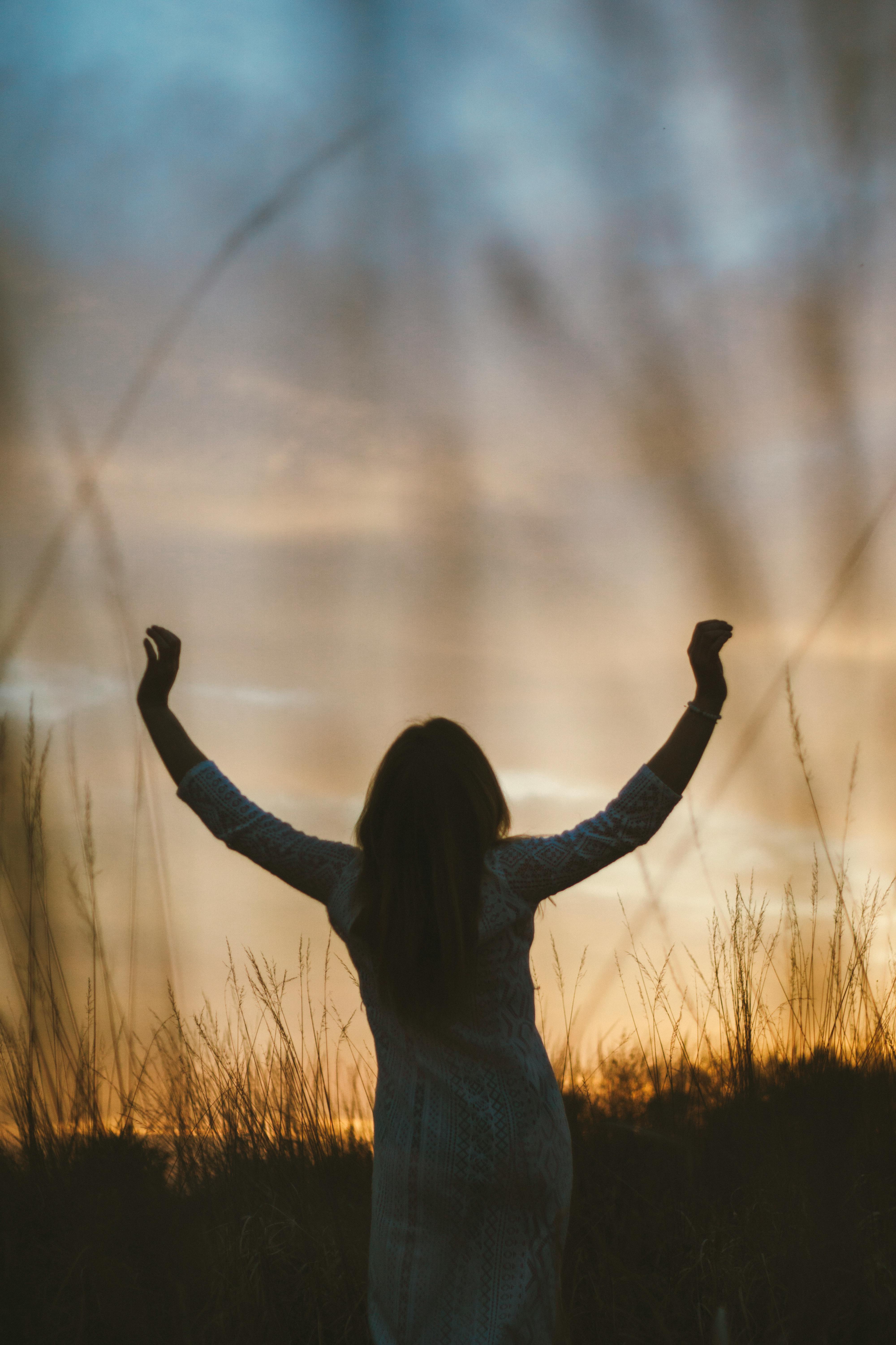 Stylish woman standing with raised arms against mountains · Free Stock ...