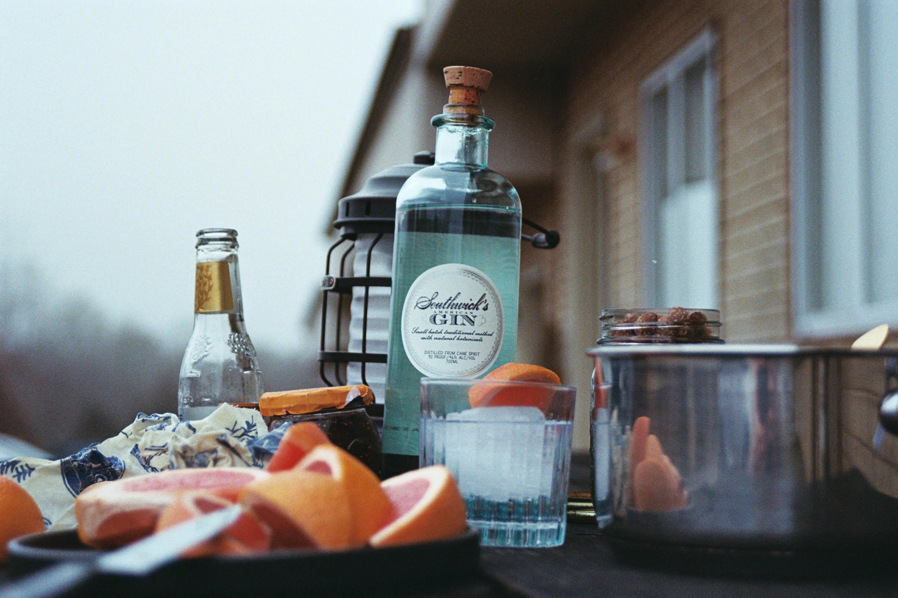 A Bottle of Gin Standing on a Table Outside · Free Stock Photo