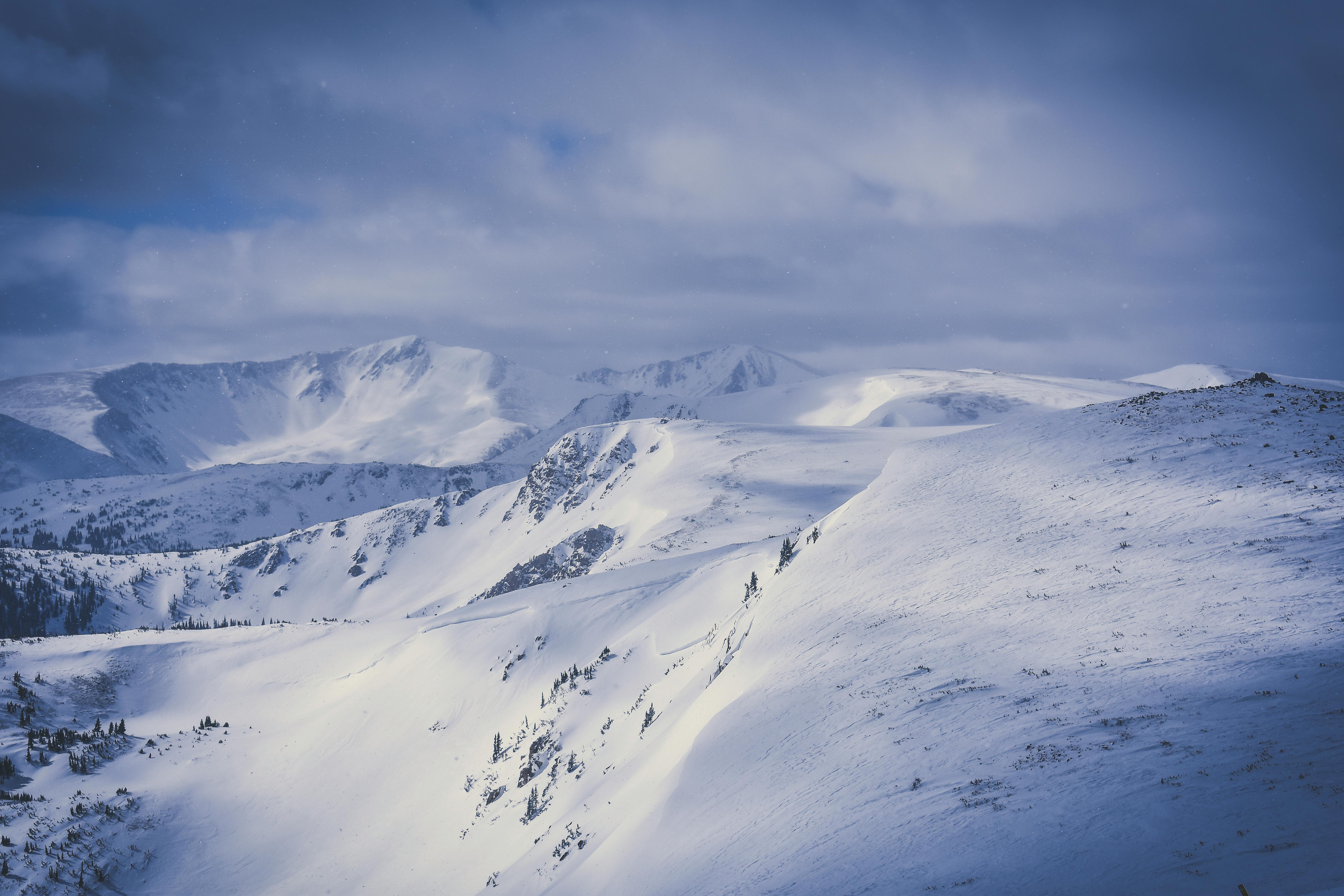 Grey Cloudy Sky over Snow Covered Mountain Ranges · Free Stock Photo