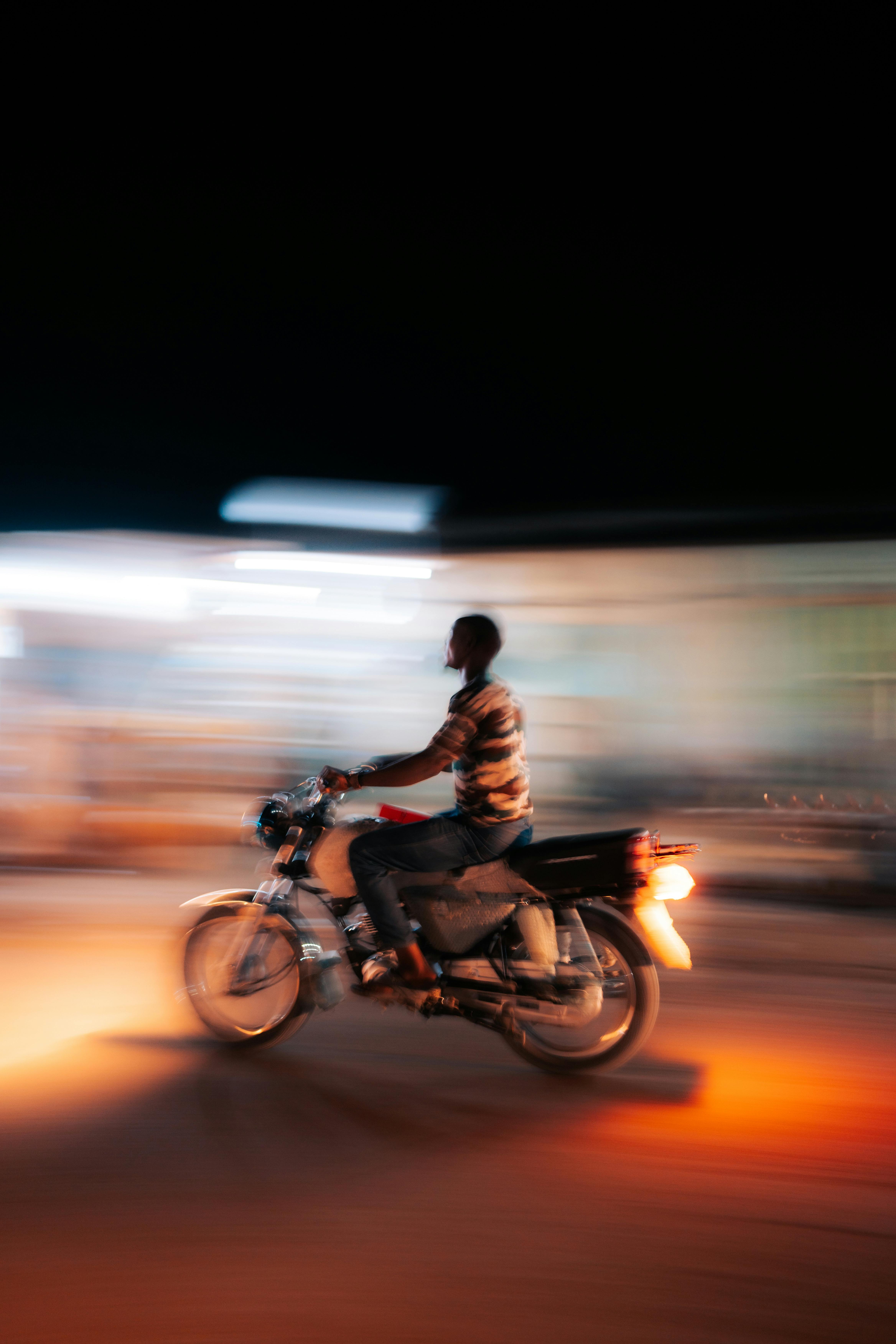 A man riding a motorcycle at night · Free Stock Photo