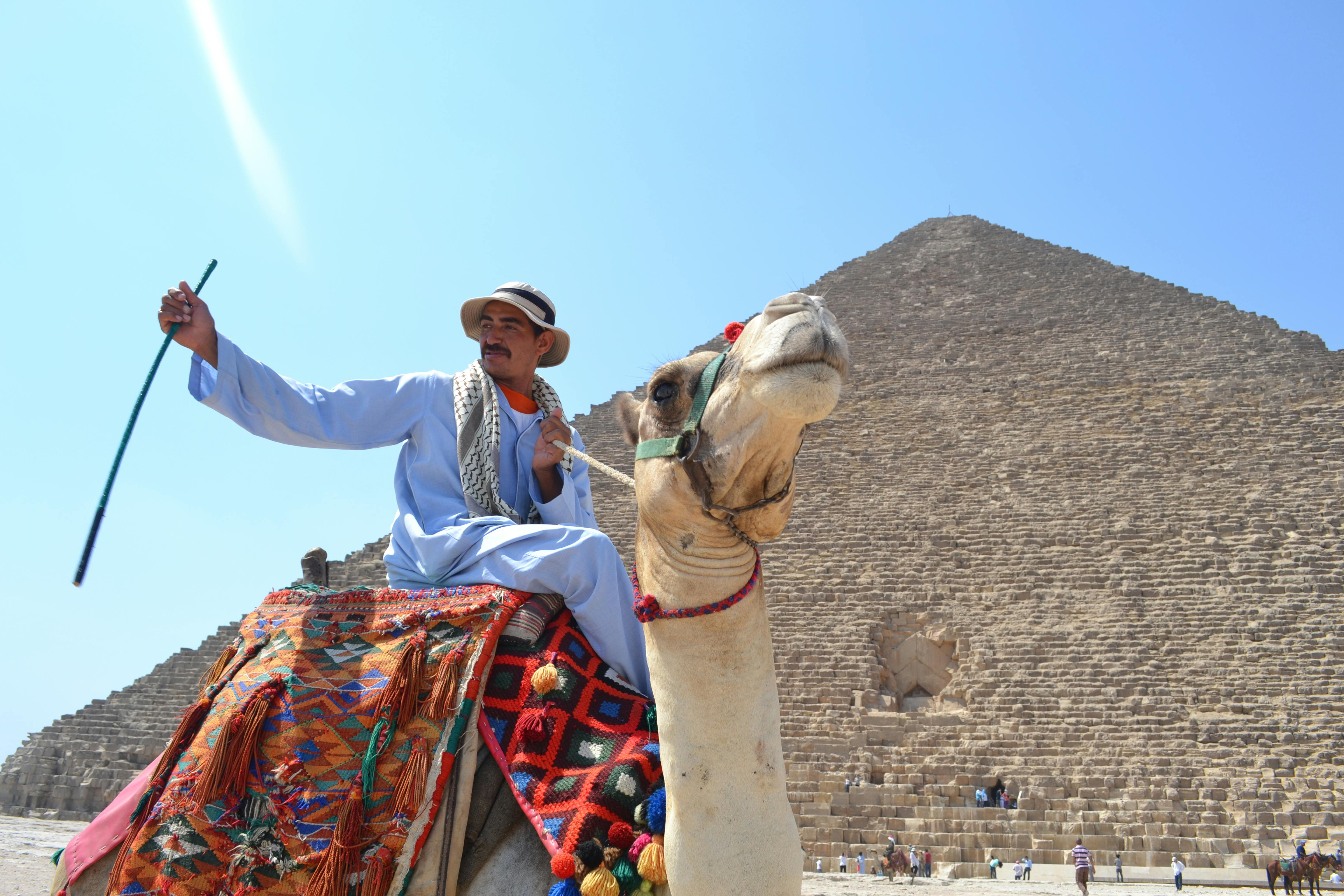 Beduin Riding a Camel in Front of a Pyramid · Free Stock Photo