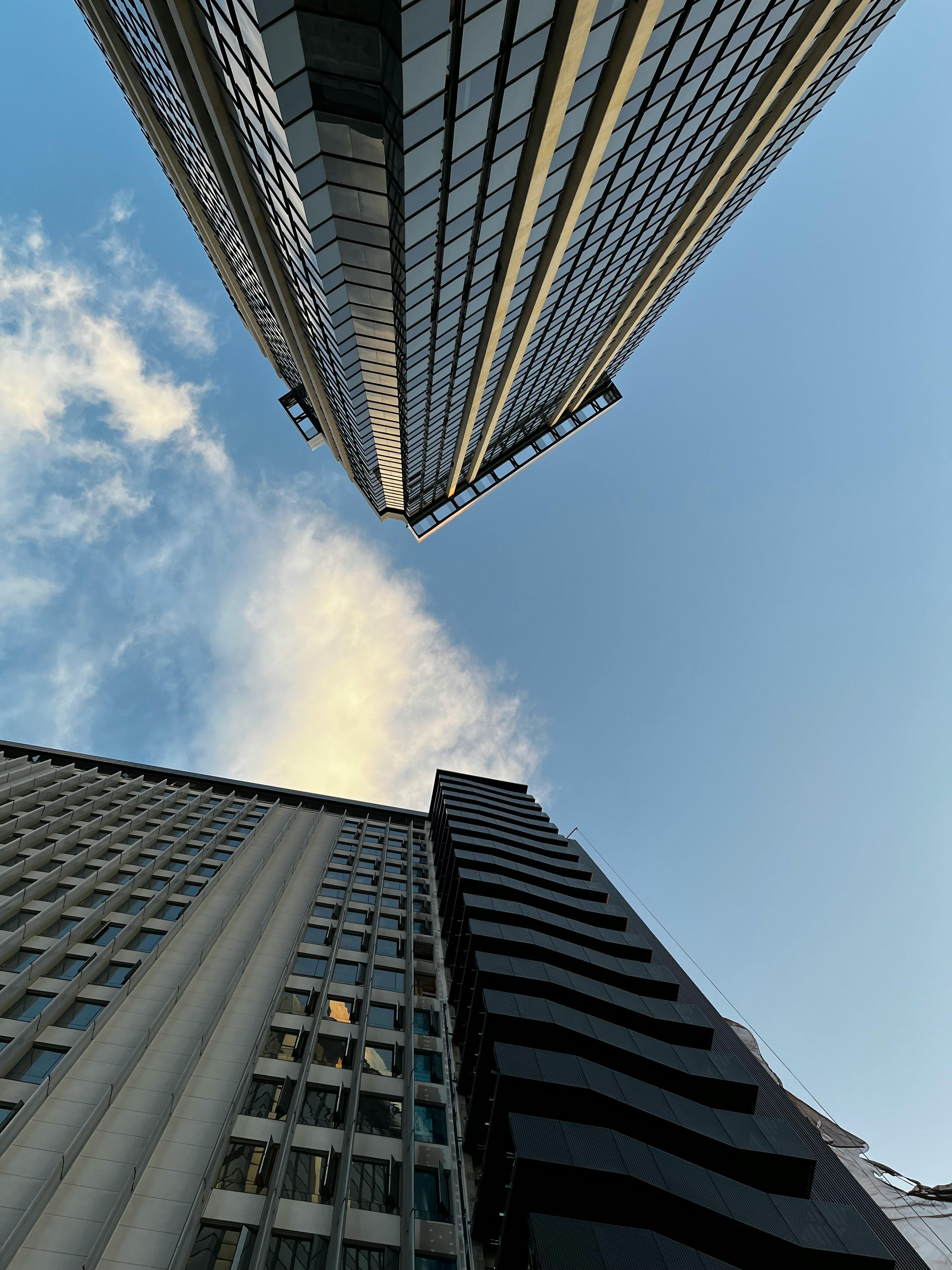 A view of two tall buildings from below · Free Stock Photo