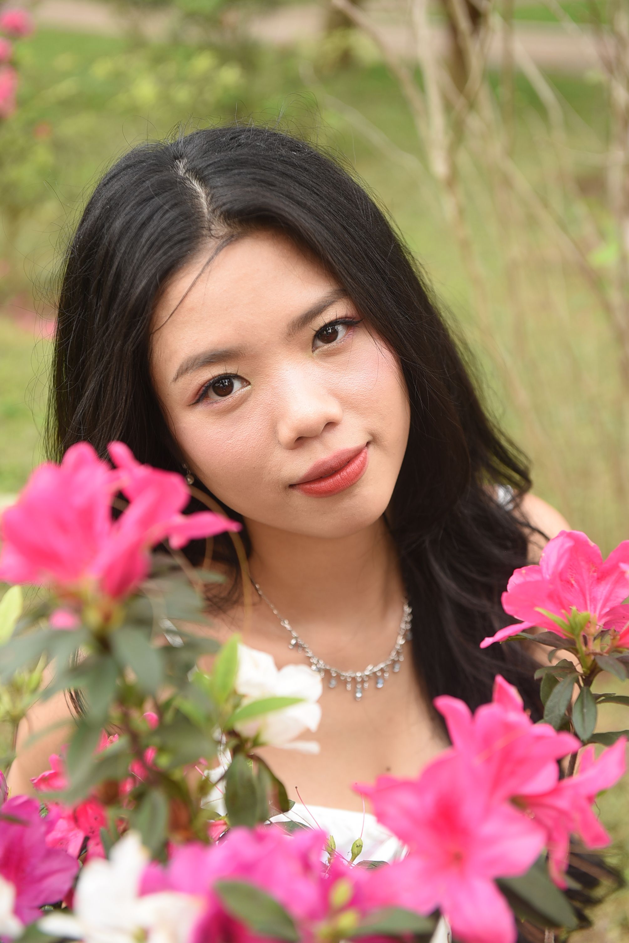 Portrait of a Woman Behind Pink Flowers · Free Stock Photo