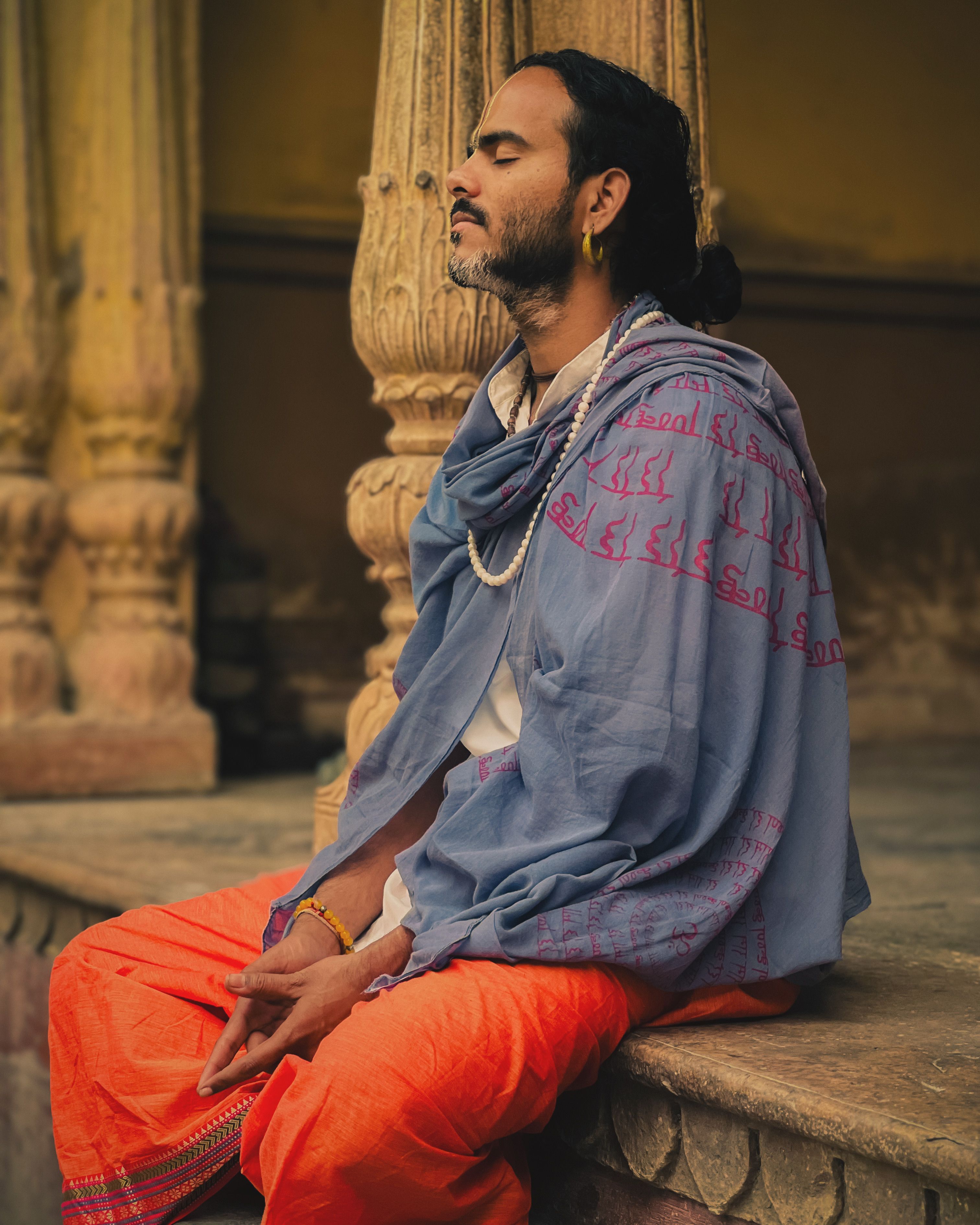 A man sitting on the steps of a temple · Free Stock Photo
