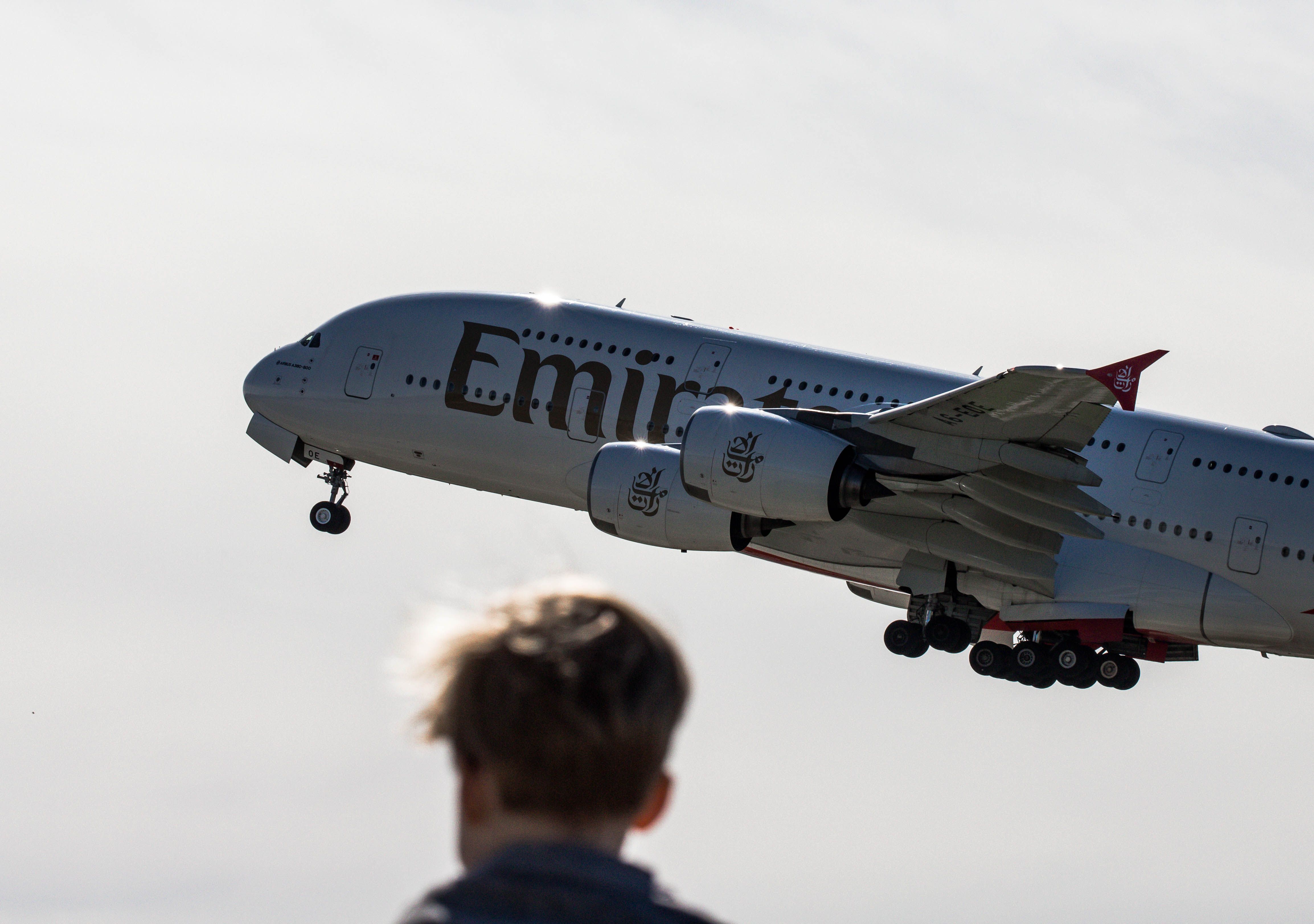 Back View of a Man Watching the Takeoff of an Emirates Airliner · Free ...