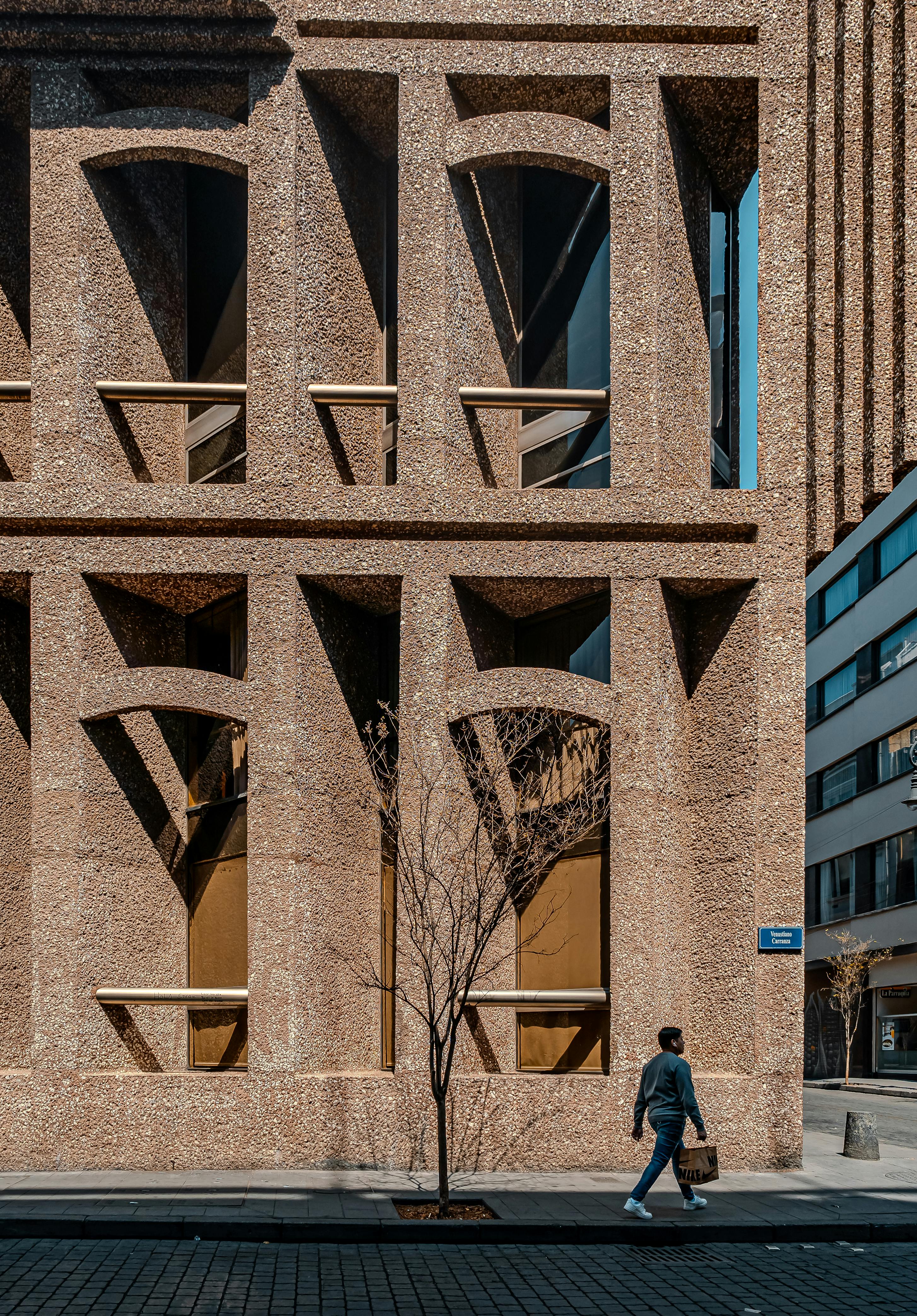 Man Walking near Building Wall · Free Stock Photo