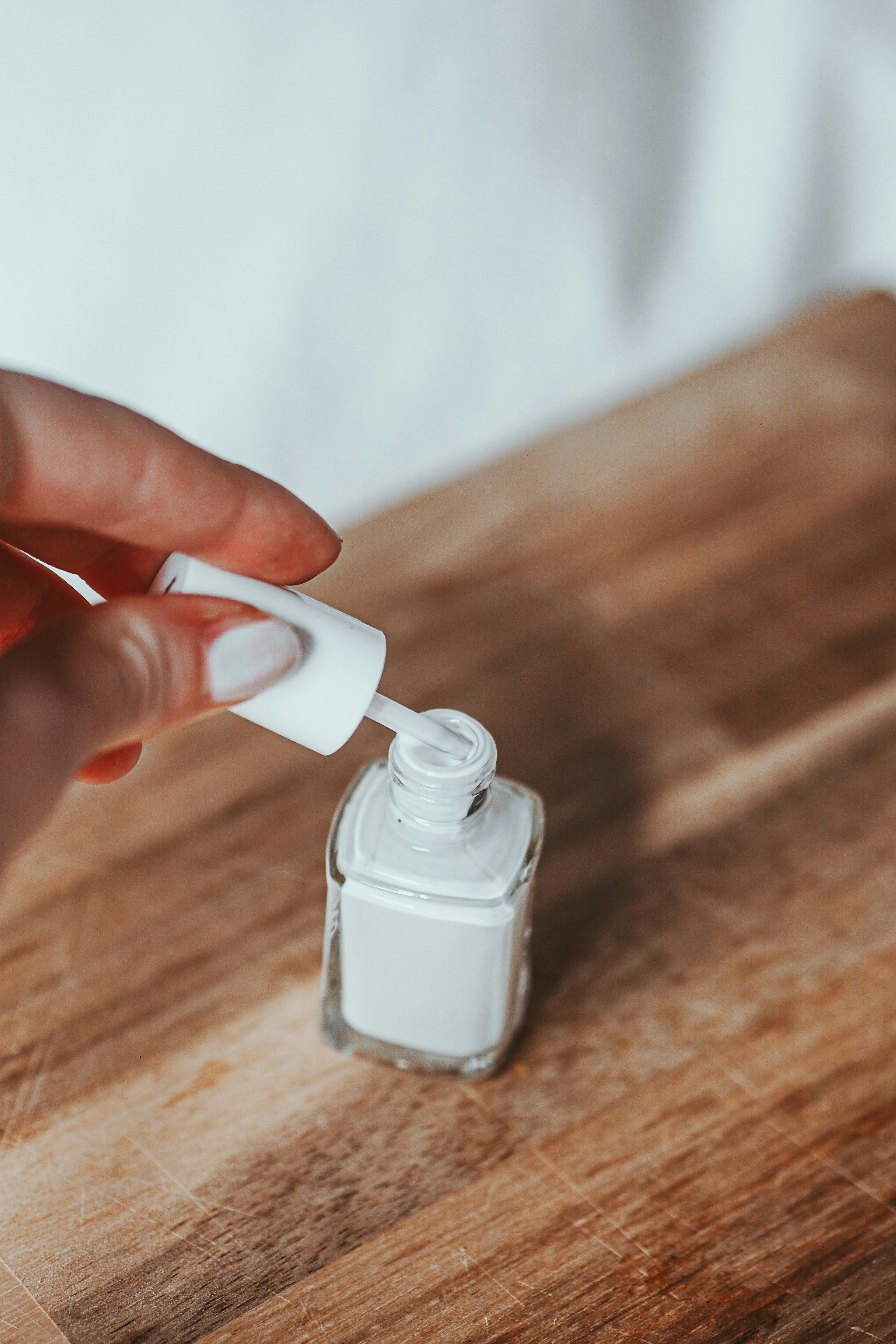 Opened White Nail Polish on Wooden Board · Free Stock Photo