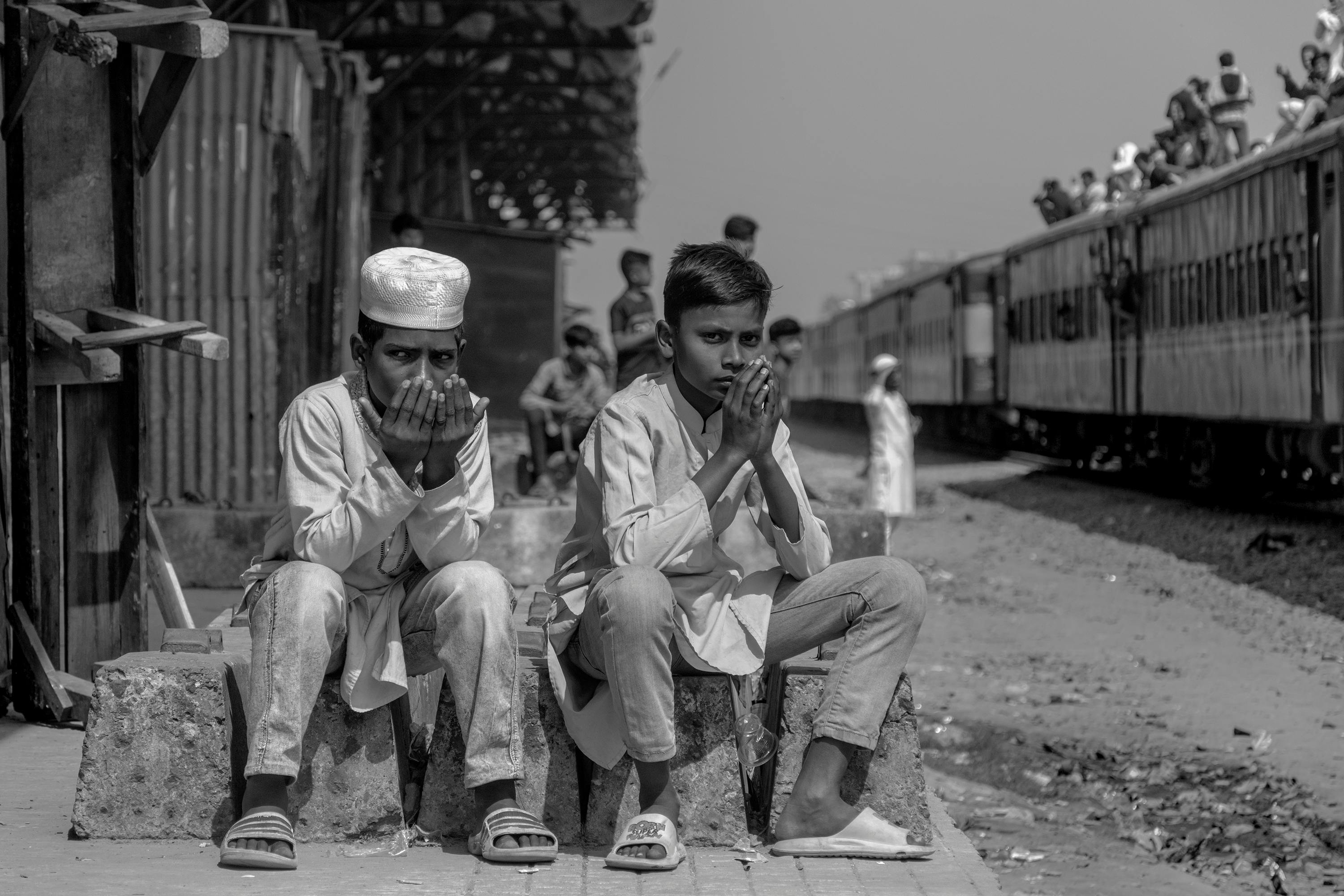 Black and White Photo of Two Boys Sitting on a Pavement near the ...
