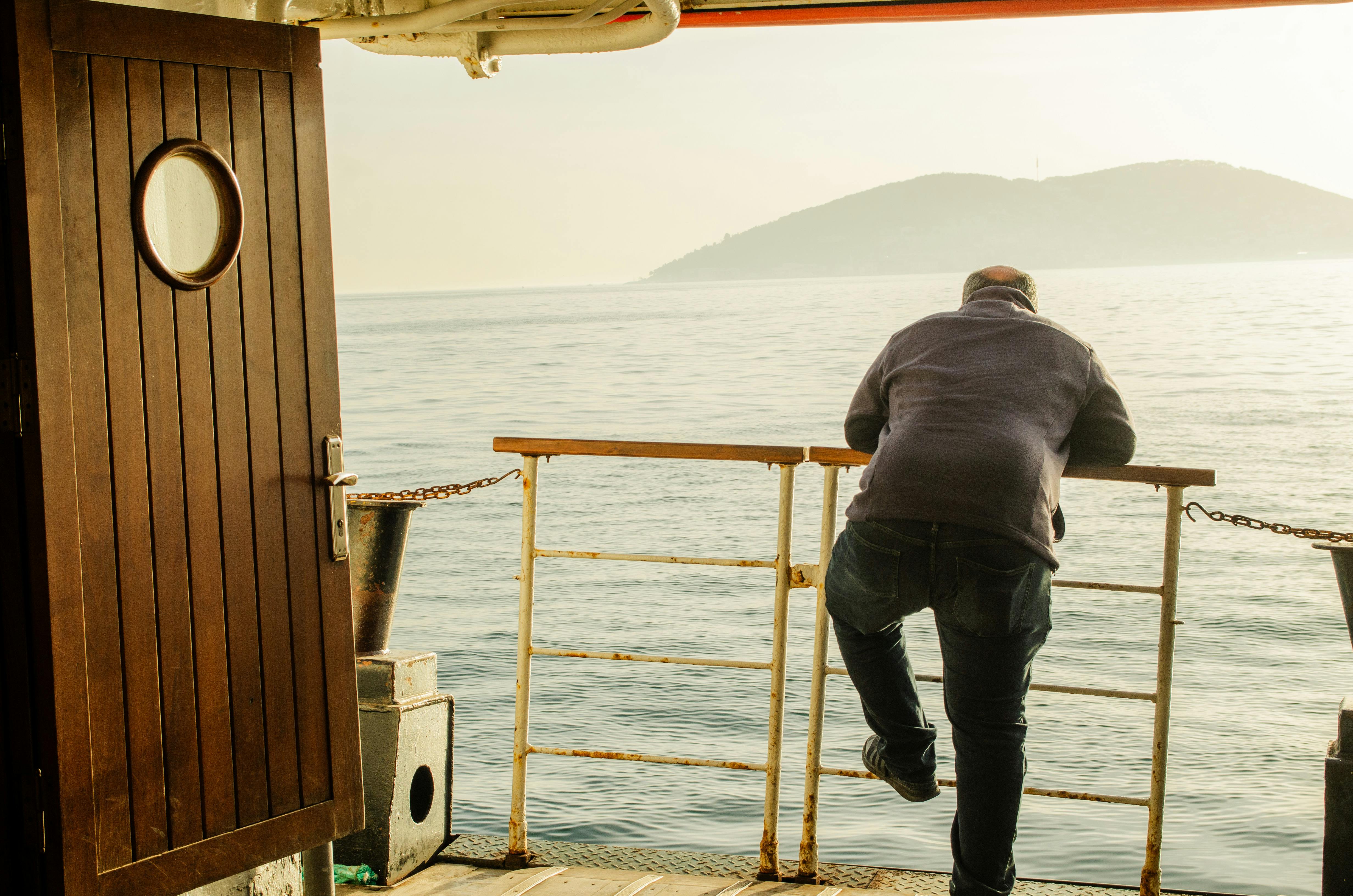 Man Standing on Boat on Sea · Free Stock Photo