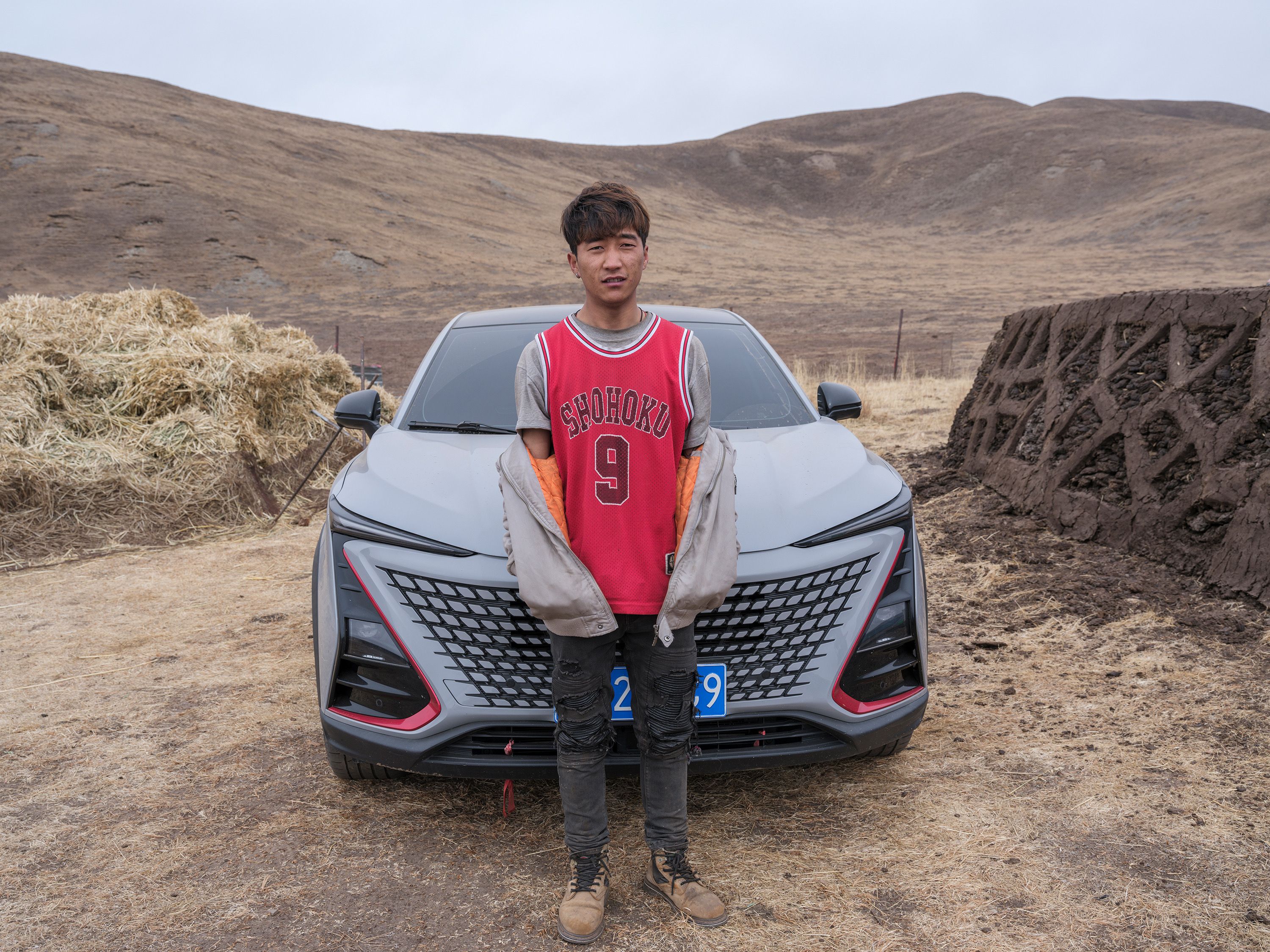 Young Man Wearing a Pink Tank Top, Posing against a Sports Car in a ...