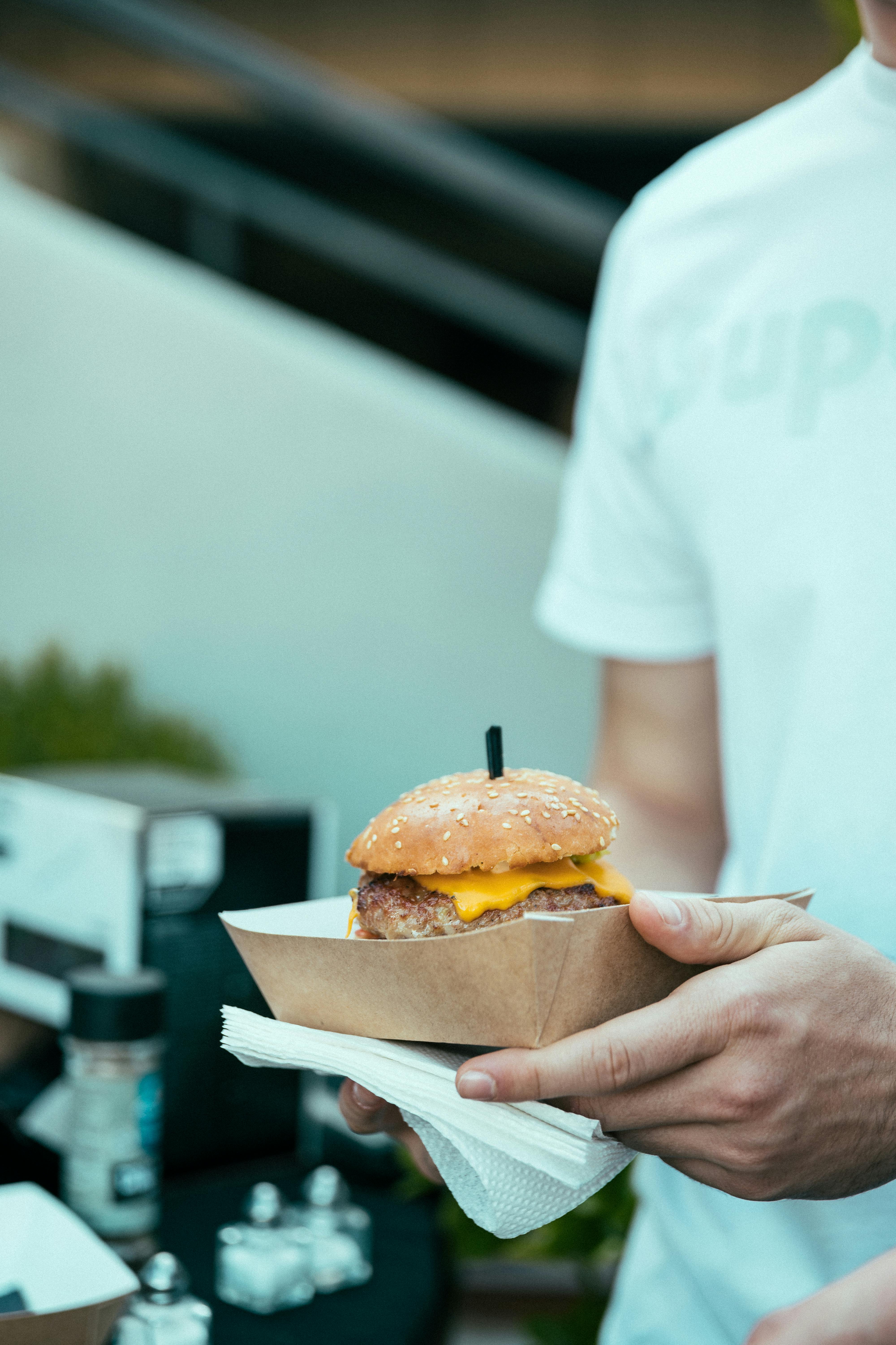 Man Holding Cheeseburger in Box · Free Stock Photo