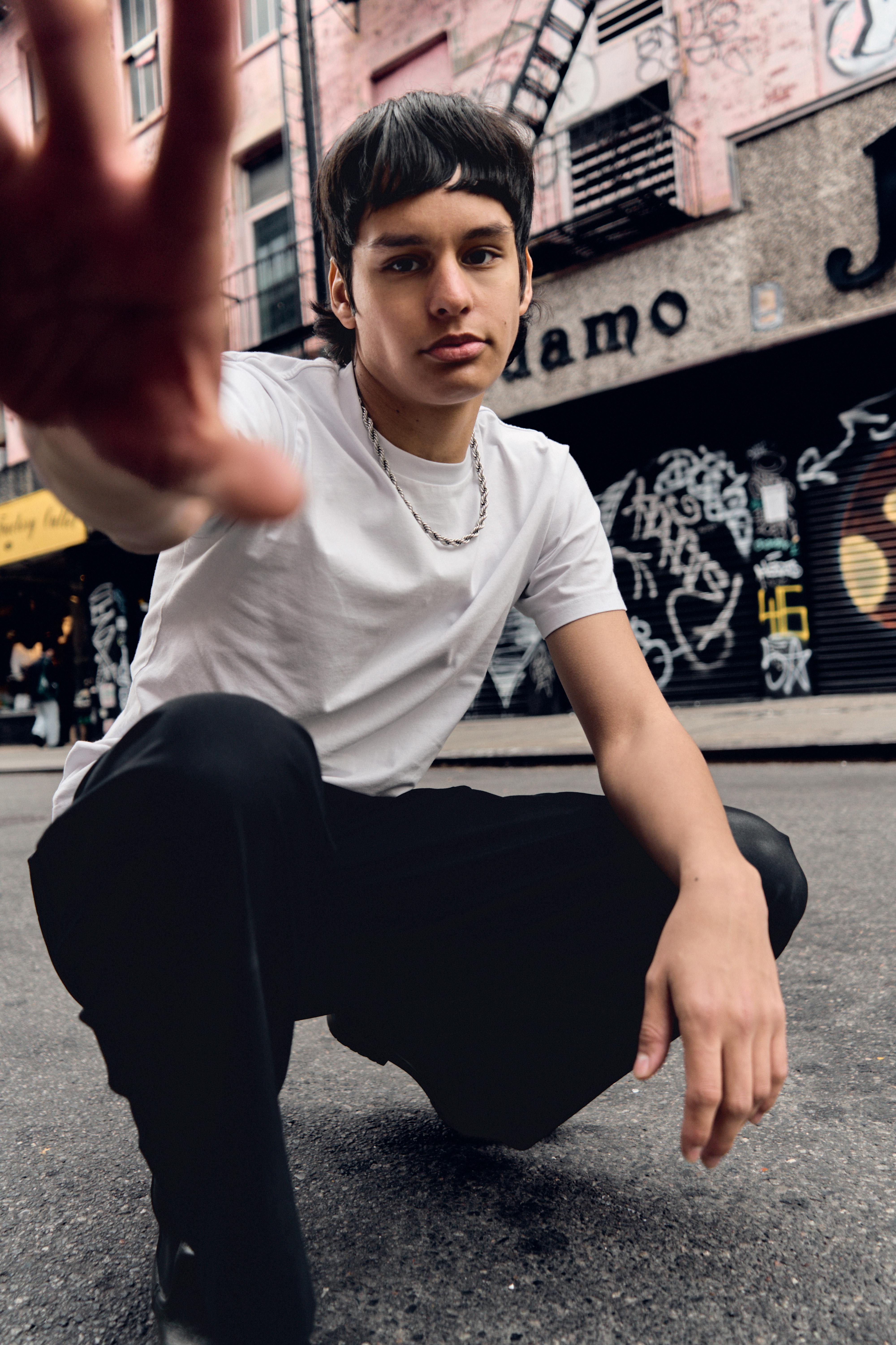 Teenager Crouching on Street · Free Stock Photo