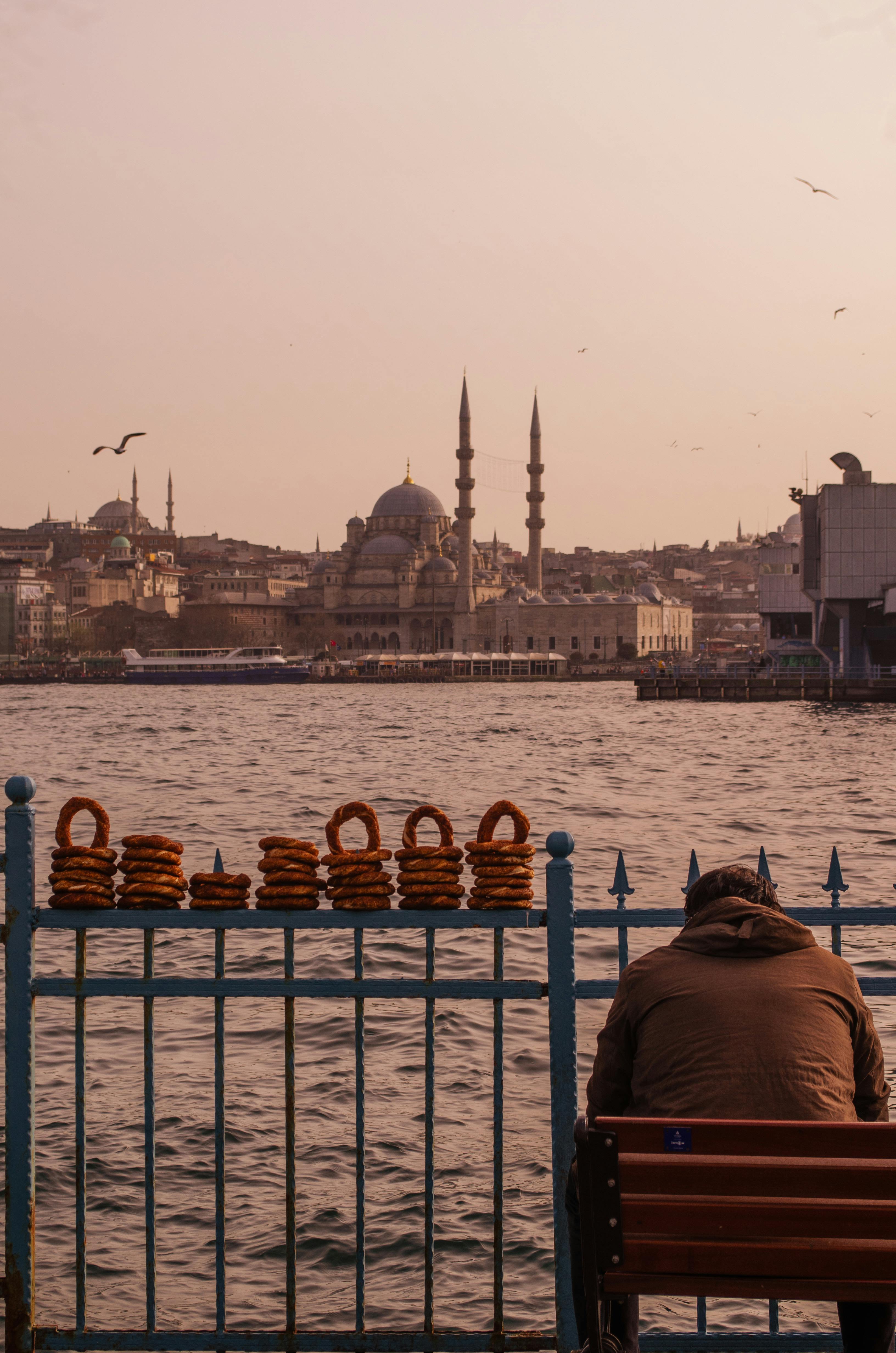 Man Sitting with Simit on Railing on Sea Shore in Istanbul · Free Stock ...