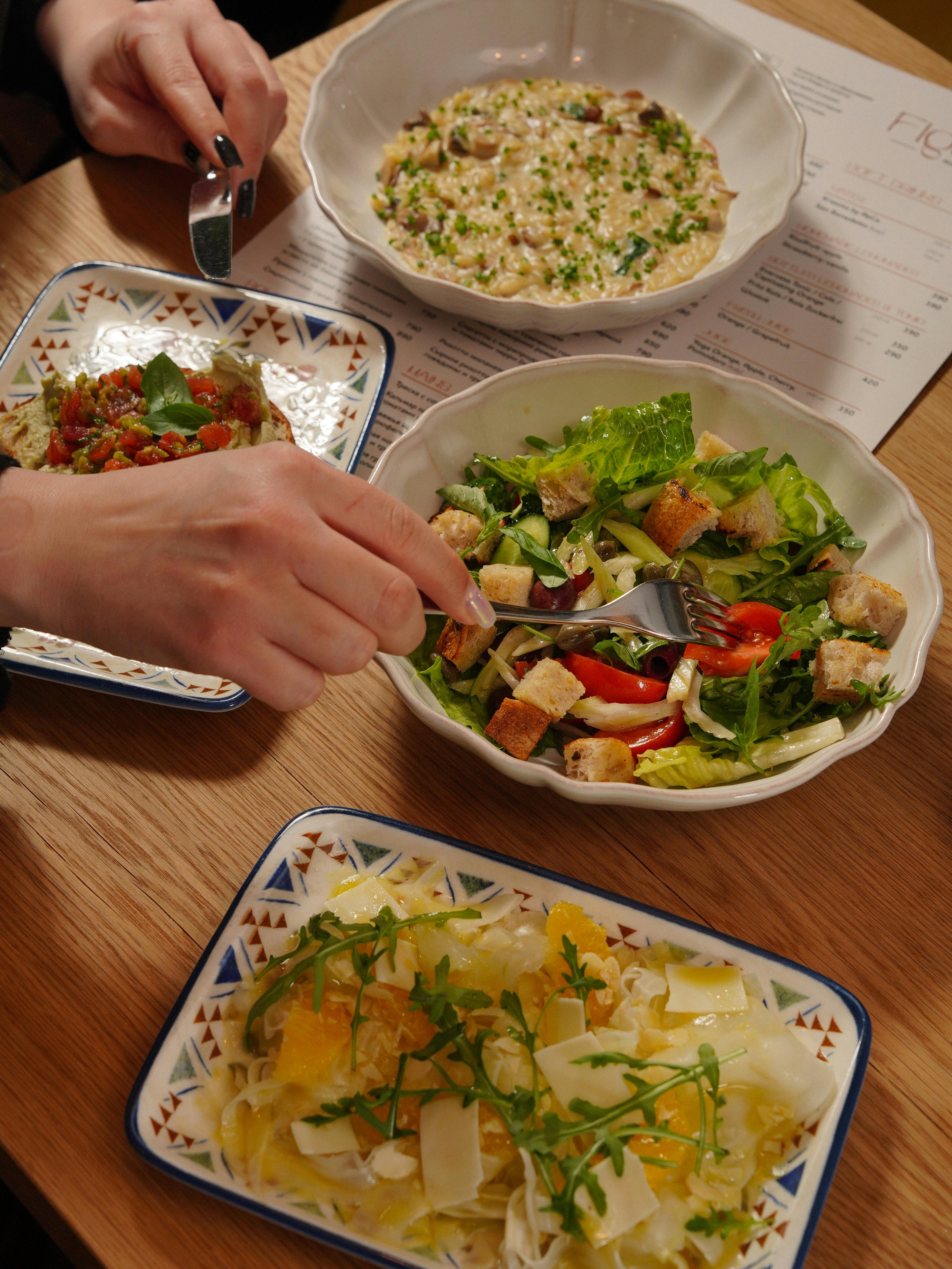 Hands of Person Eating Salads in Restaurant · Free Stock Photo