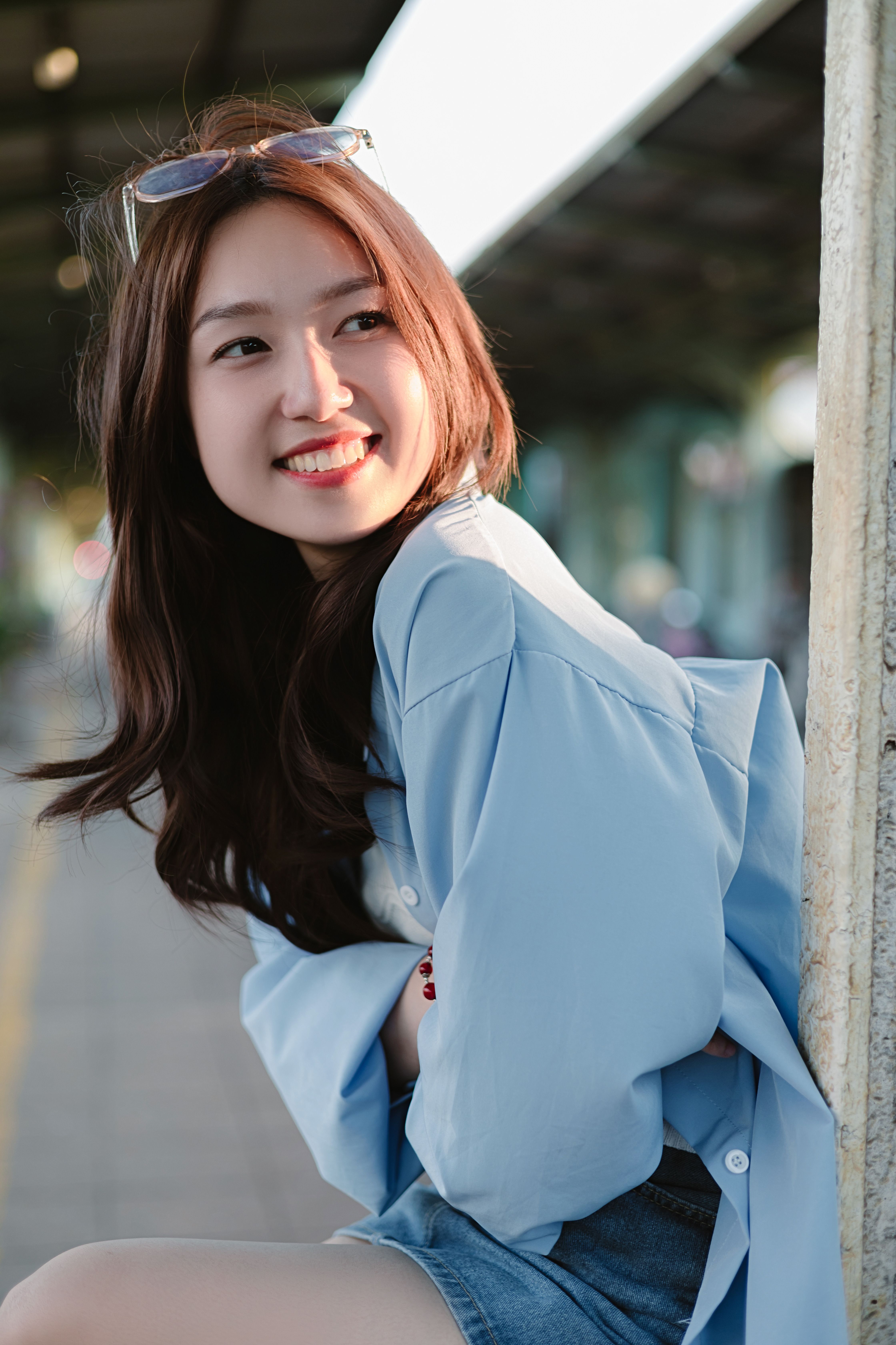 Happy Woman in Blue Posing by Concrete Pillar · Free Stock Photo
