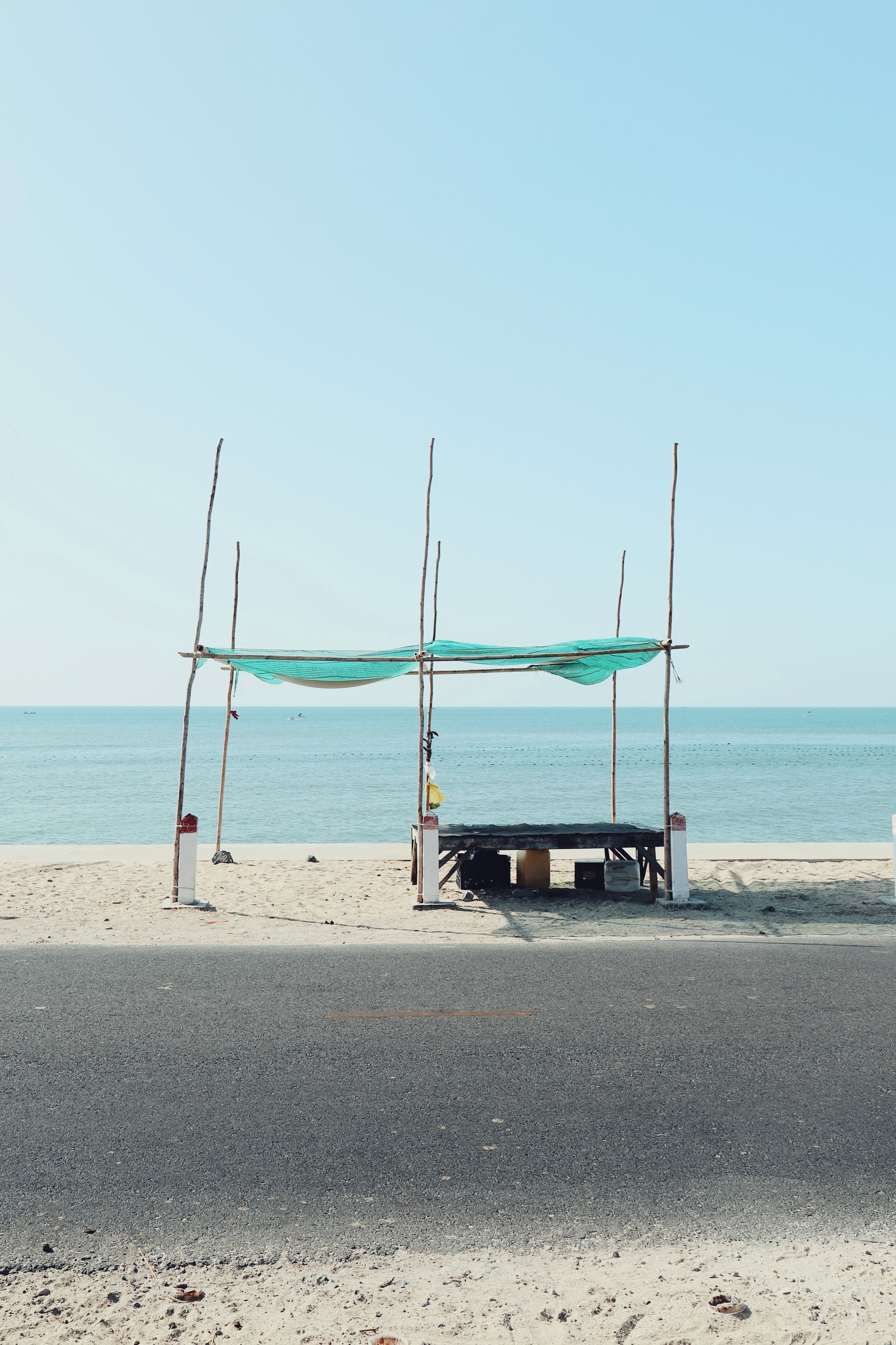 Blue Cloth on Wooden Sticks on Beach · Free Stock Photo