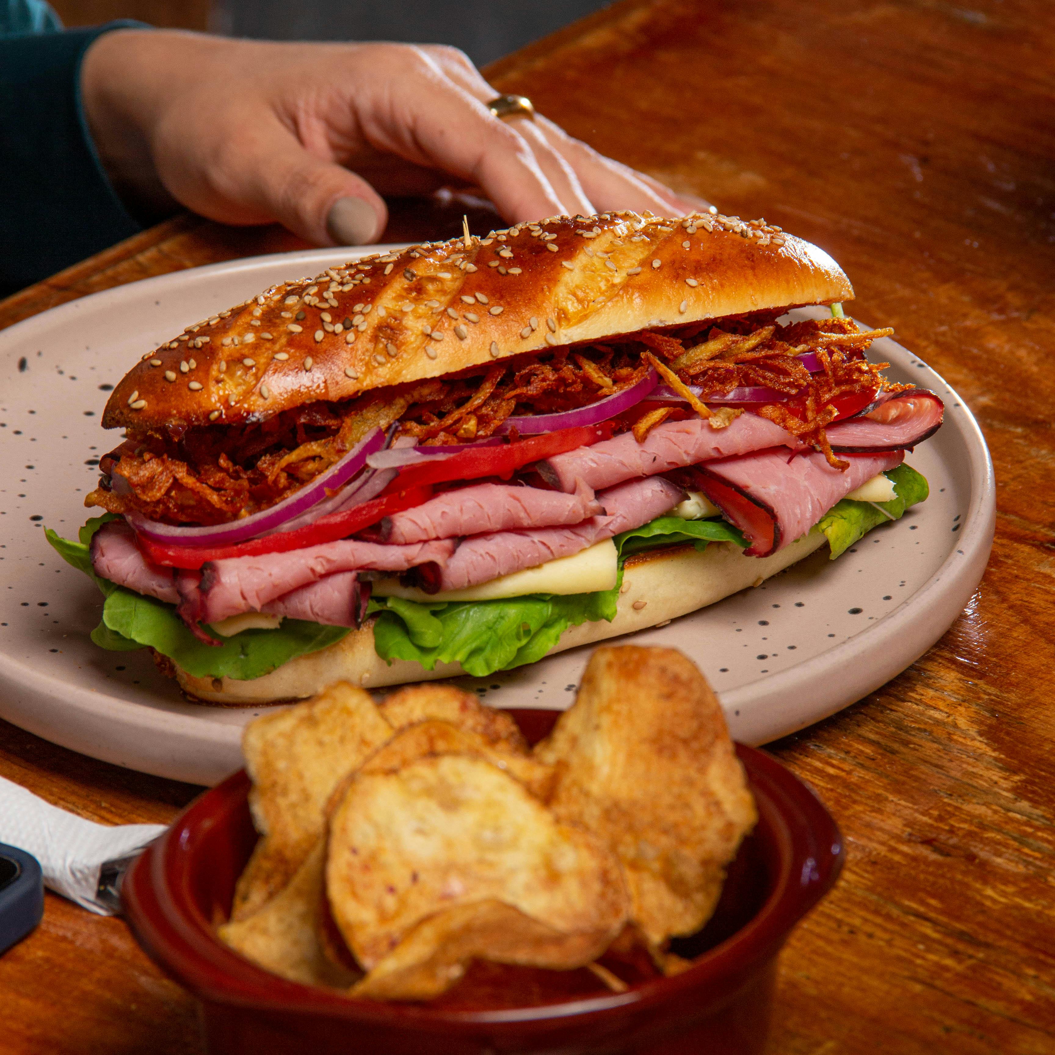 Person Slicing Sandwich Bread · Free Stock Photo
