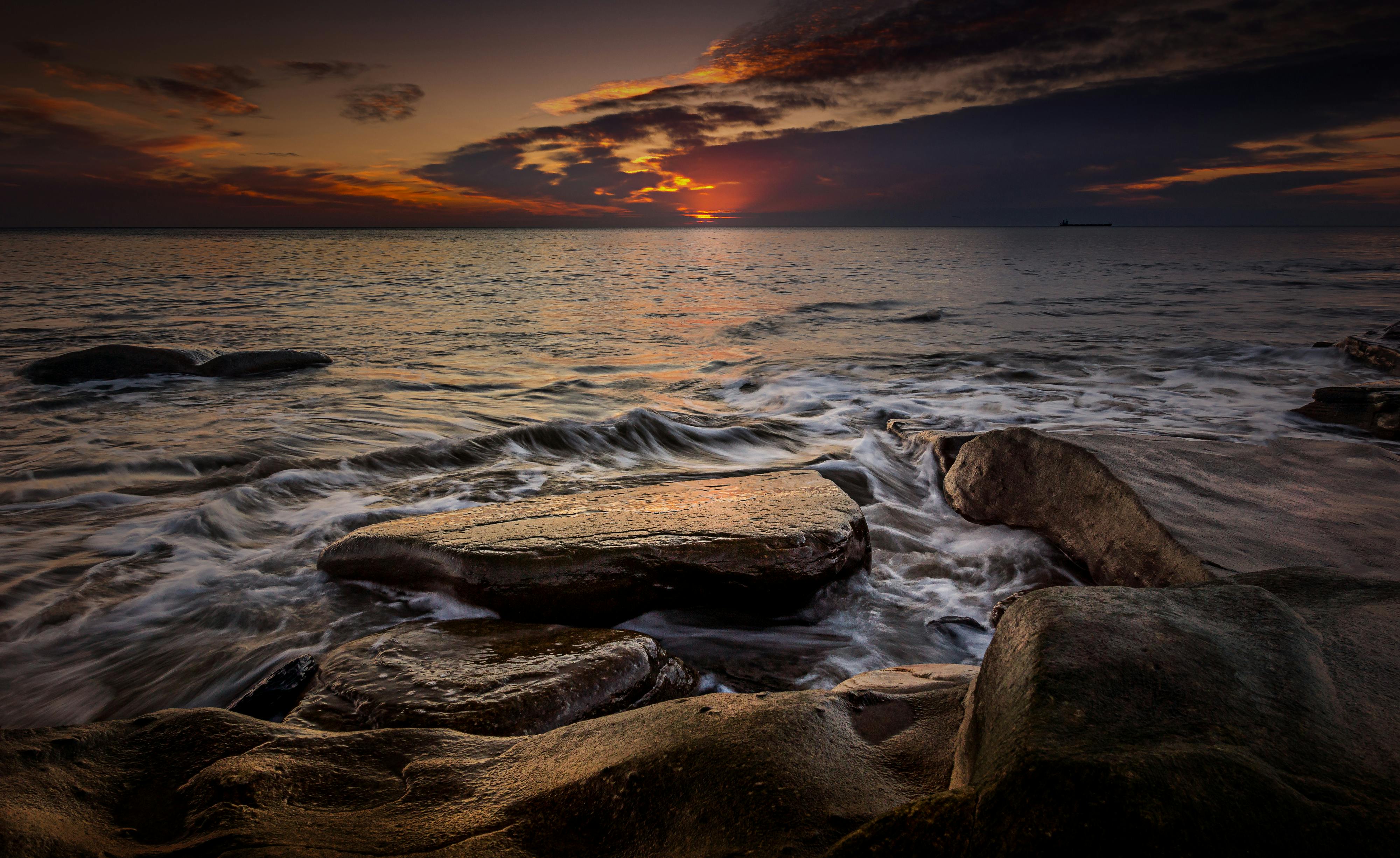 Sea Waves Hitting the Rock Against Landscape Background · Free Stock Photo