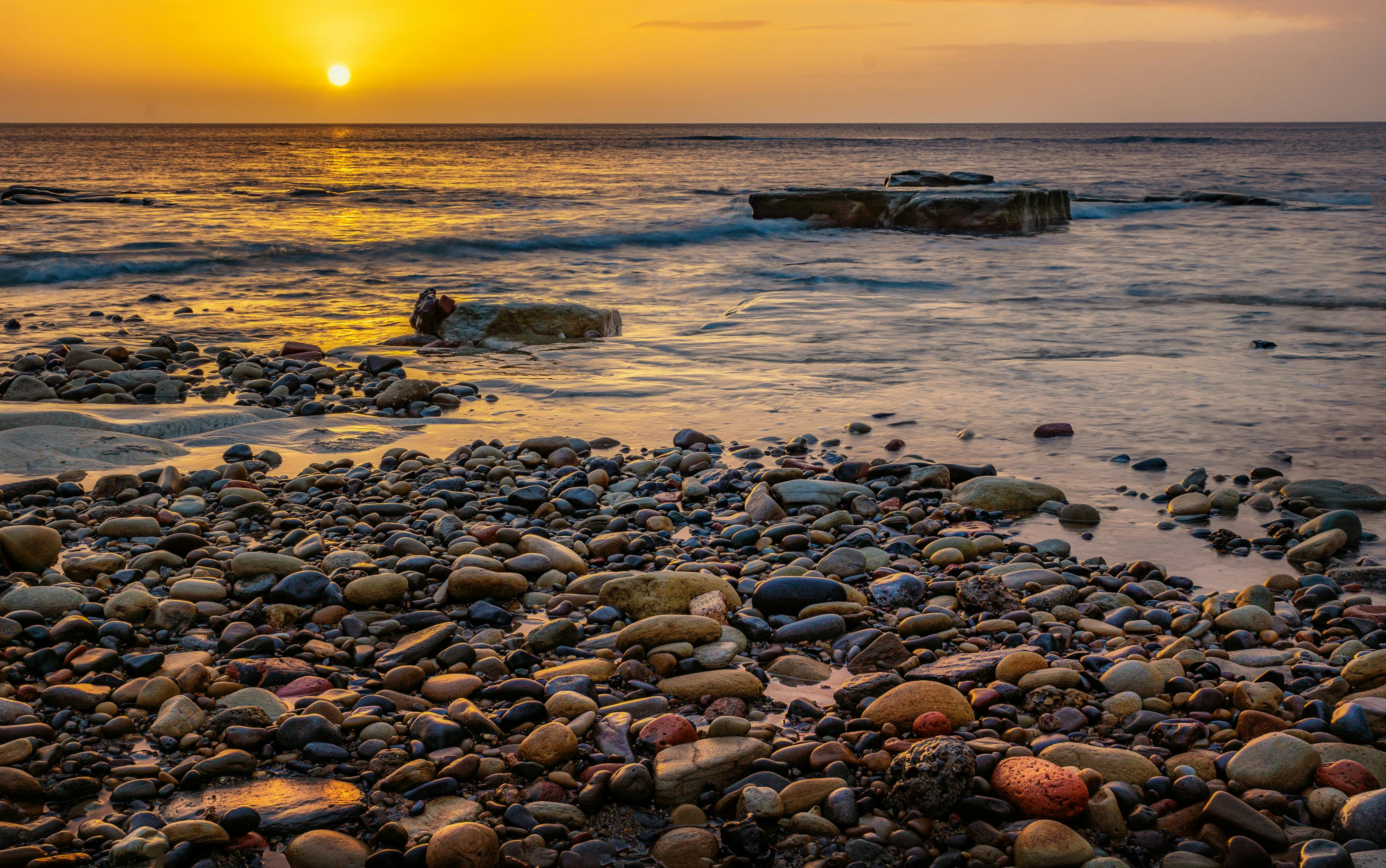 Stones on Sea Shore at Sunset · Free Stock Photo