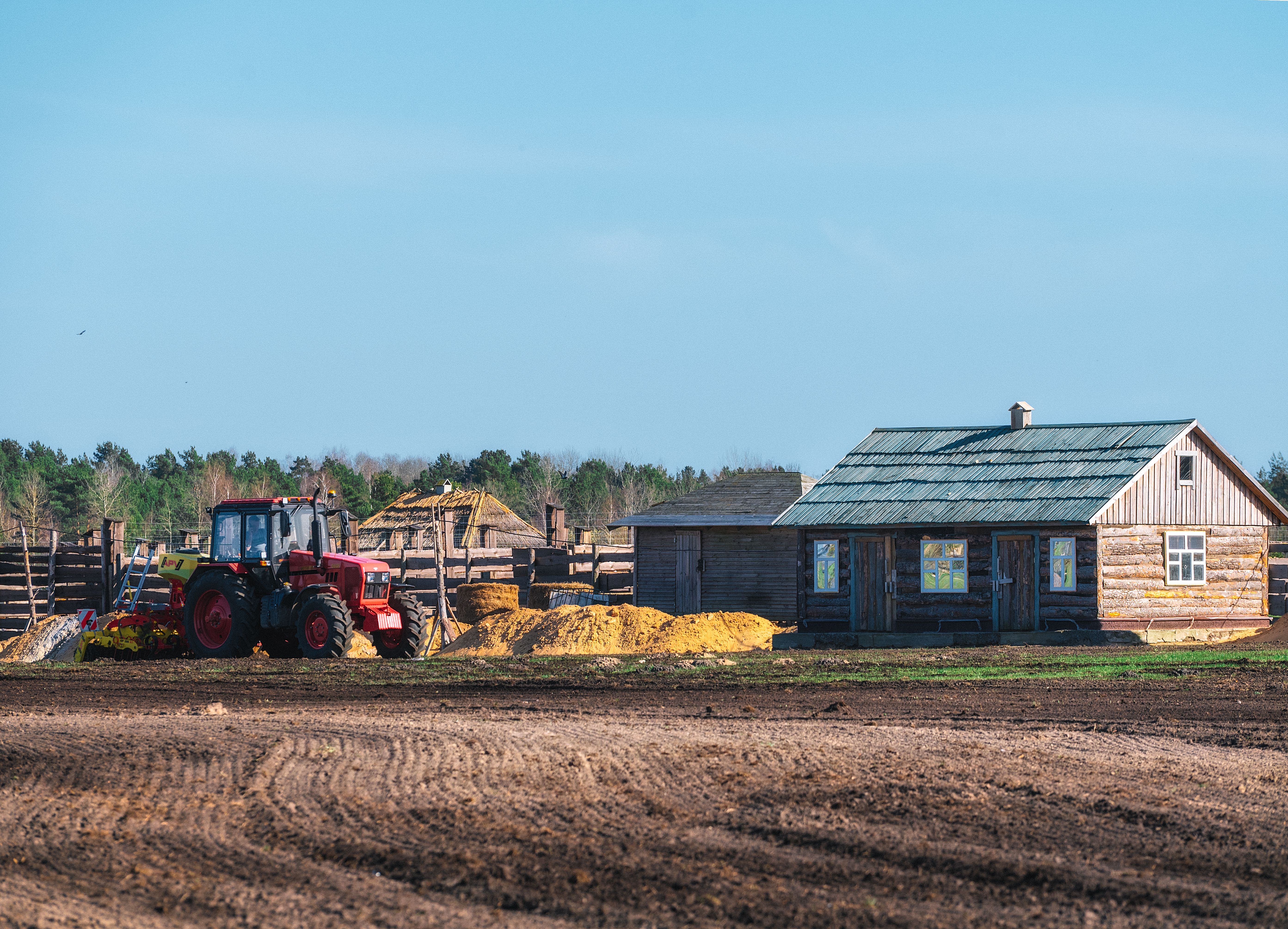Red Tractor and Farmhouse by Brown Field · Free Stock Photo