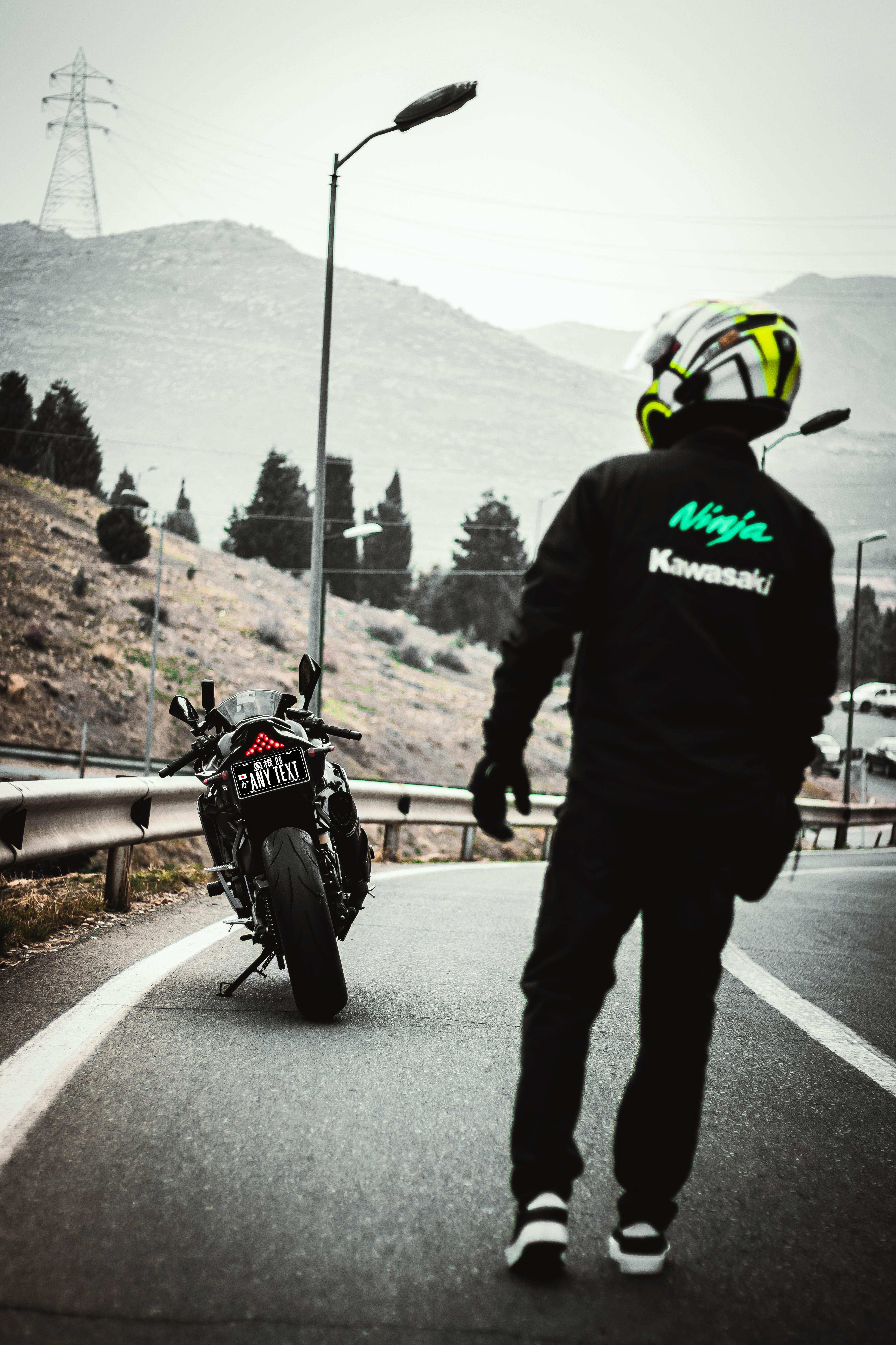 Man Walking towards Motorcycle Parked on Road · Free Stock Photo