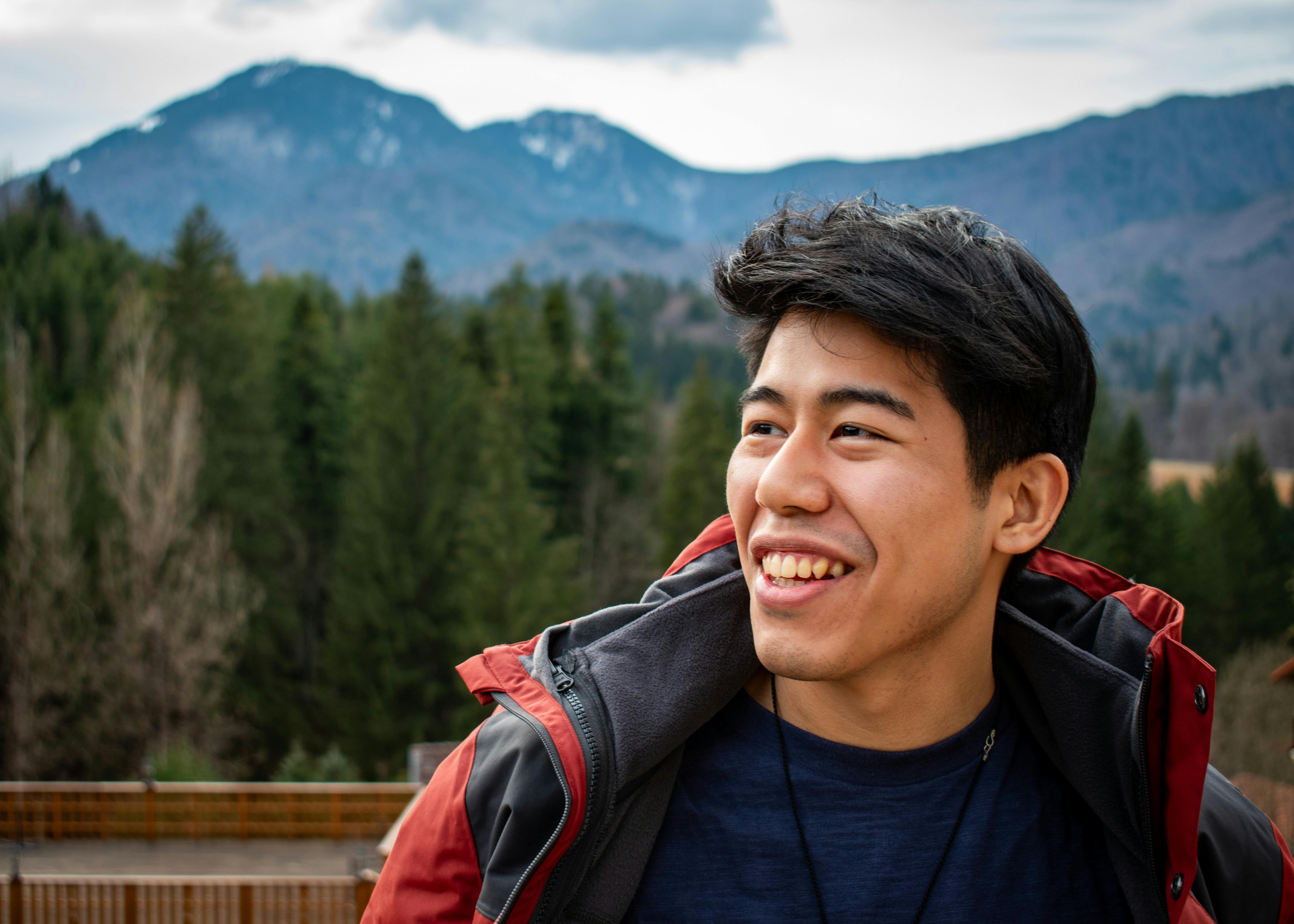 Portrait of a Male Hiker Smiling against Mountains · Free Stock Photo