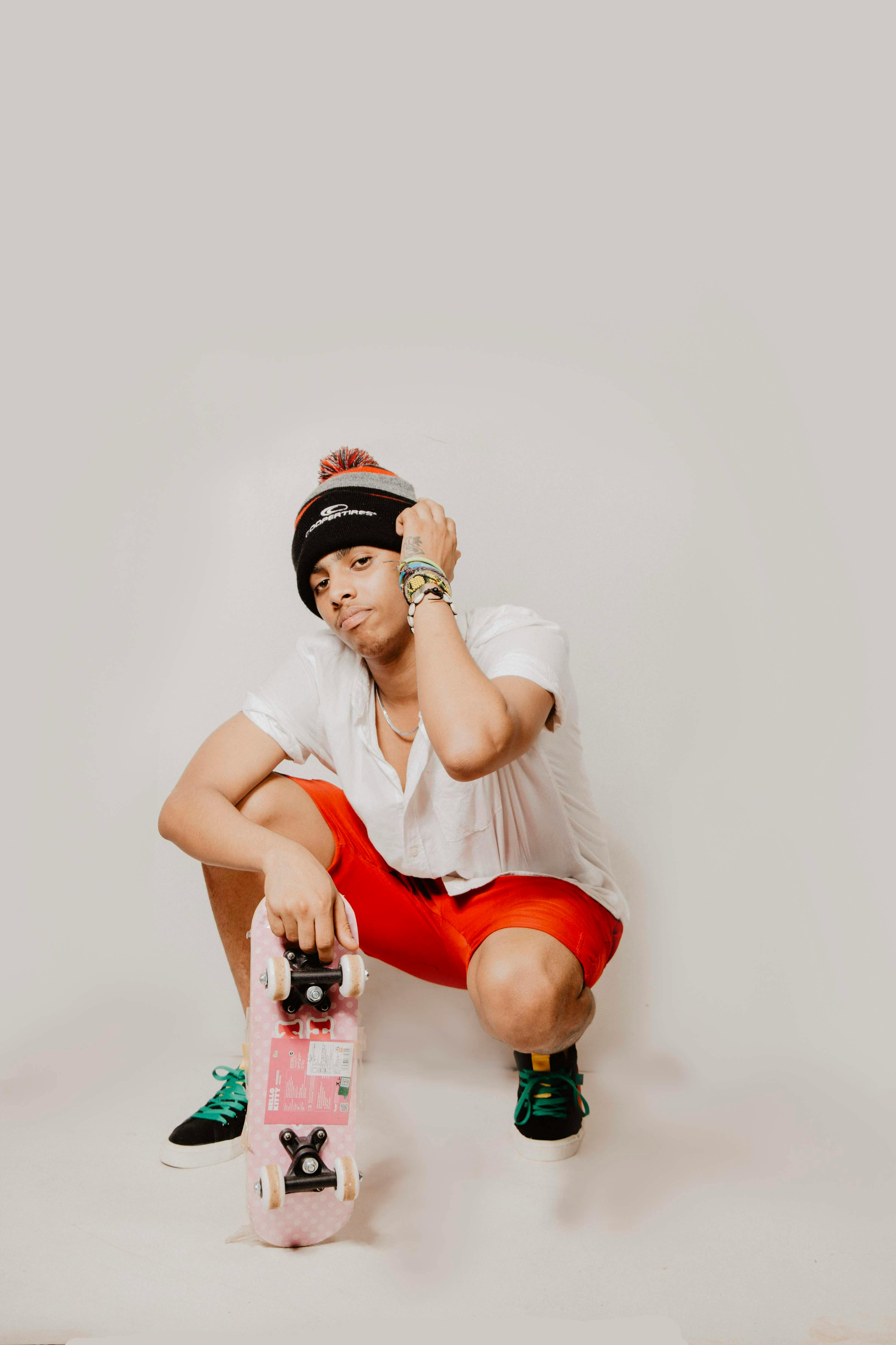 A man kneeling down with a skateboard · Free Stock Photo