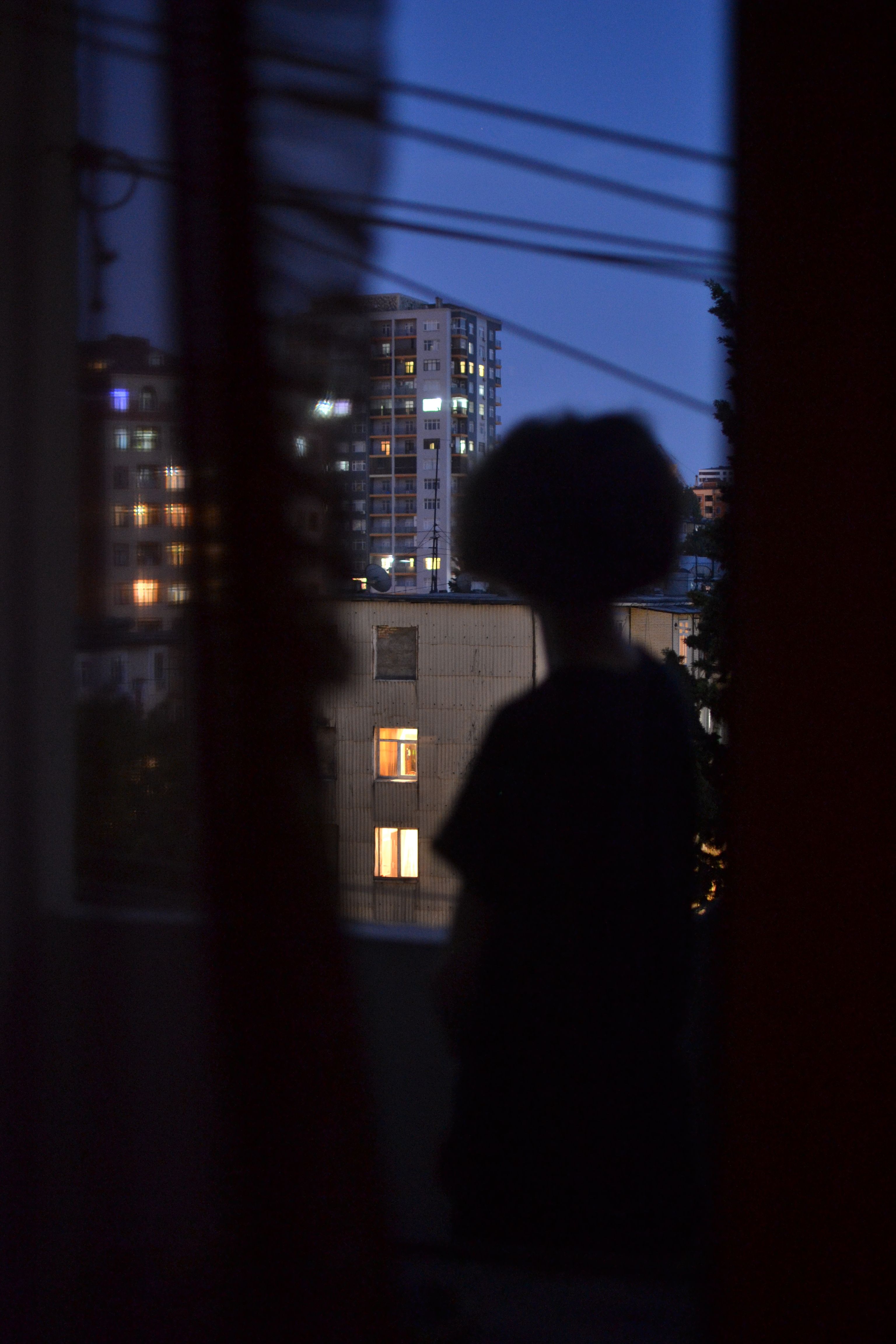 A person looking out of a window at night · Free Stock Photo