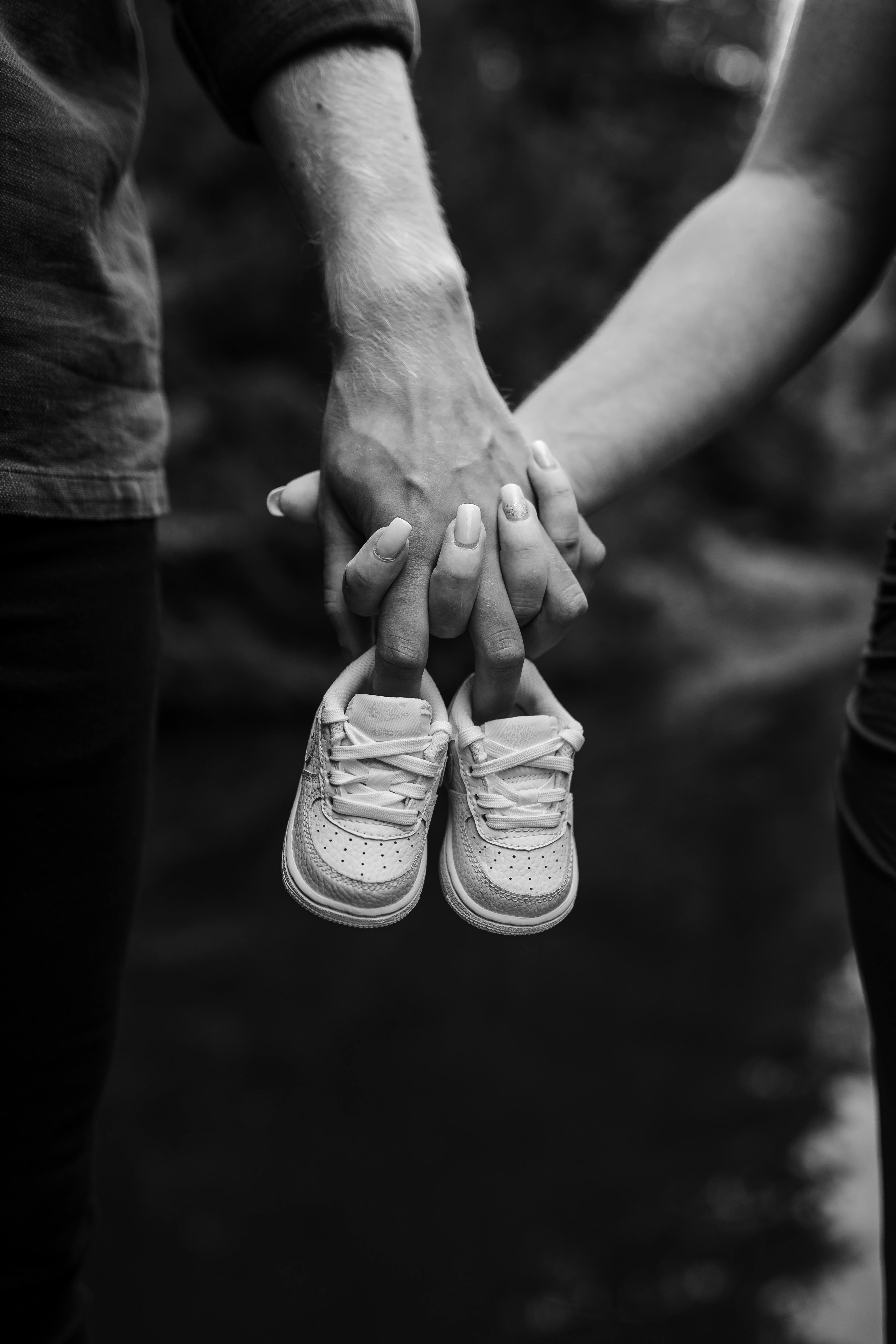 Couple Holding Hands and a Pair of Baby Shoes · Free Stock Photo
