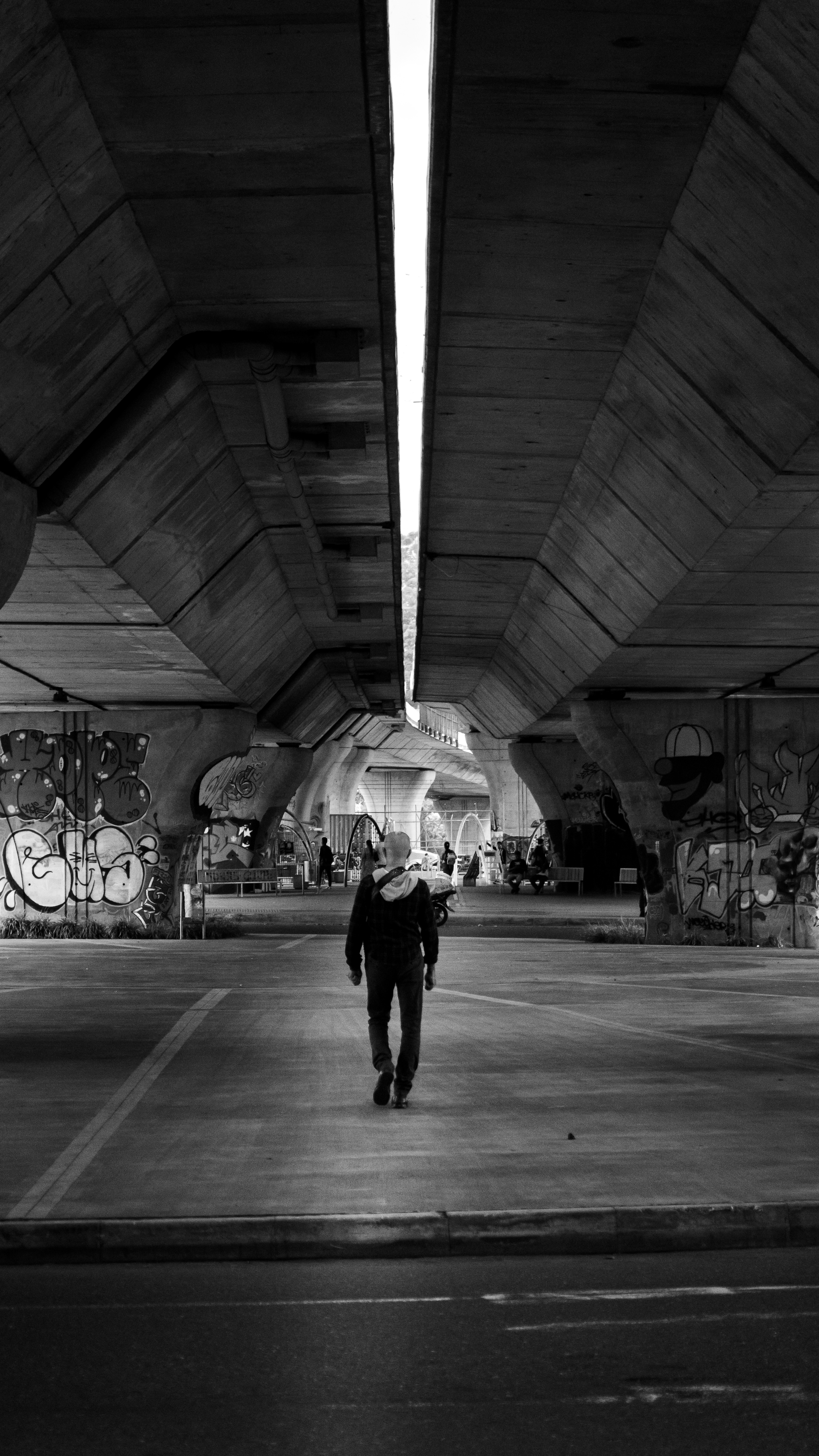 Greyscale Photography of Man Walking on Tunnel · Free Stock Photo