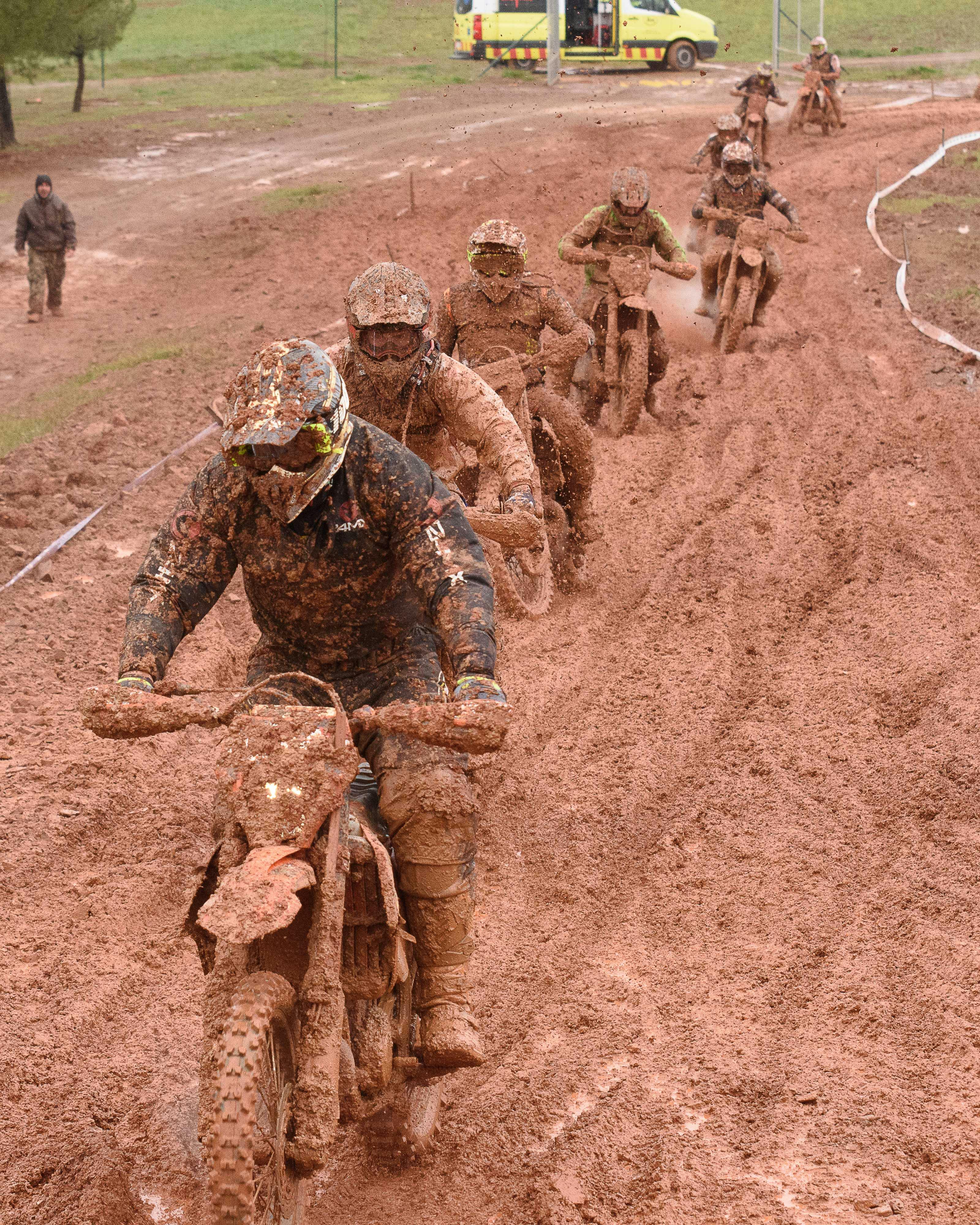 A group of people riding dirt bikes on a muddy trail · Free Stock Photo
