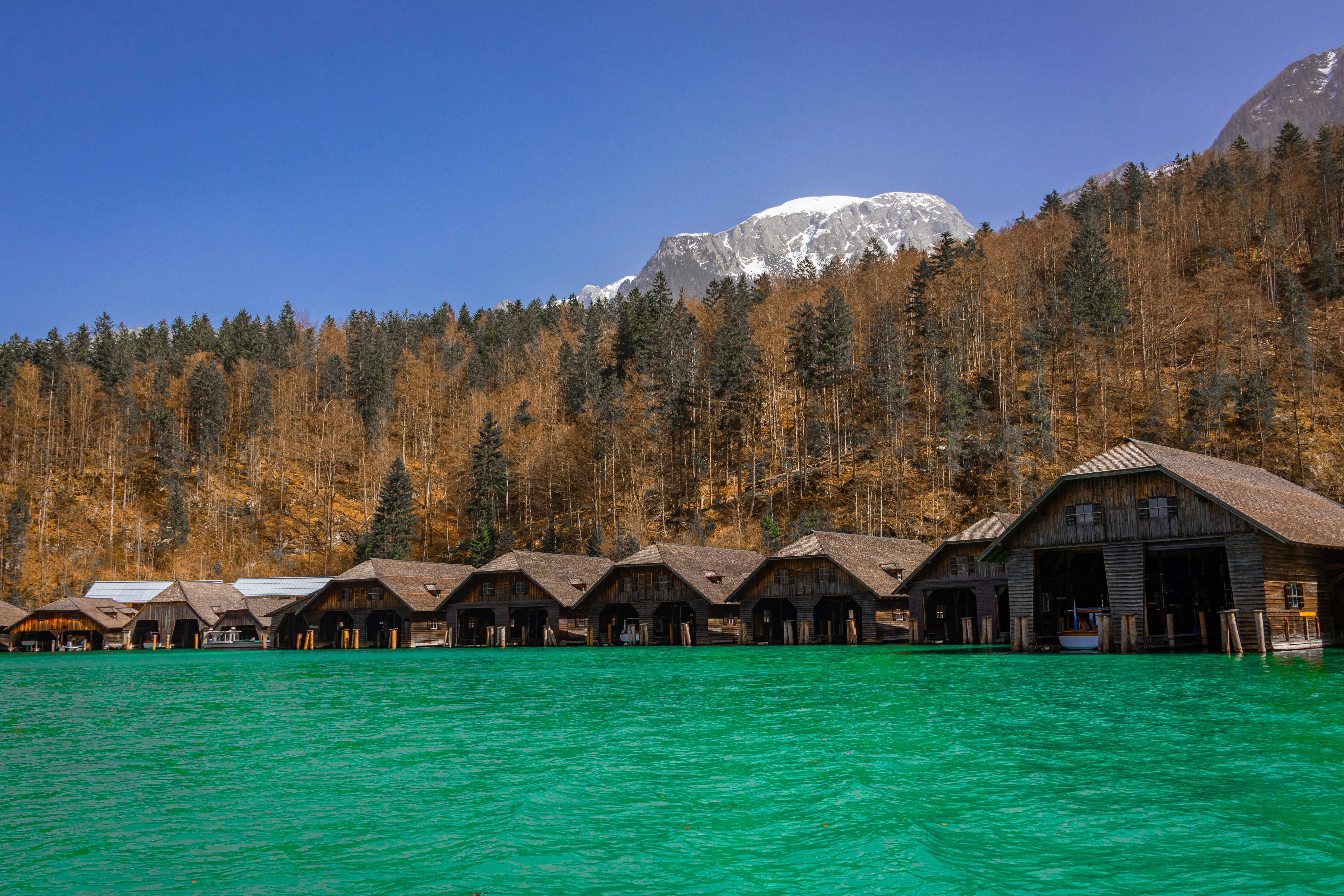 A lake with a row of wooden huts on it · Free Stock Photo