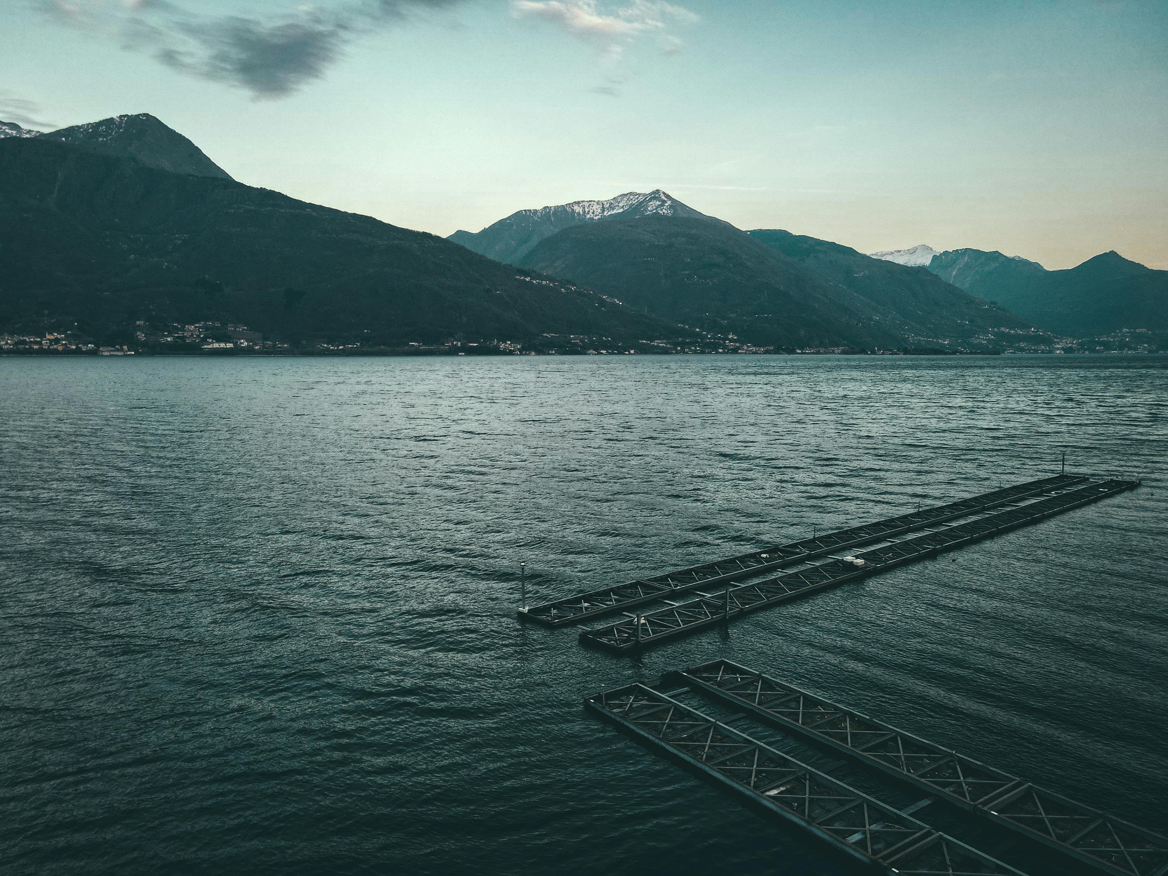 Platforms on Sea Near Mountains on Shore · Free Stock Photo