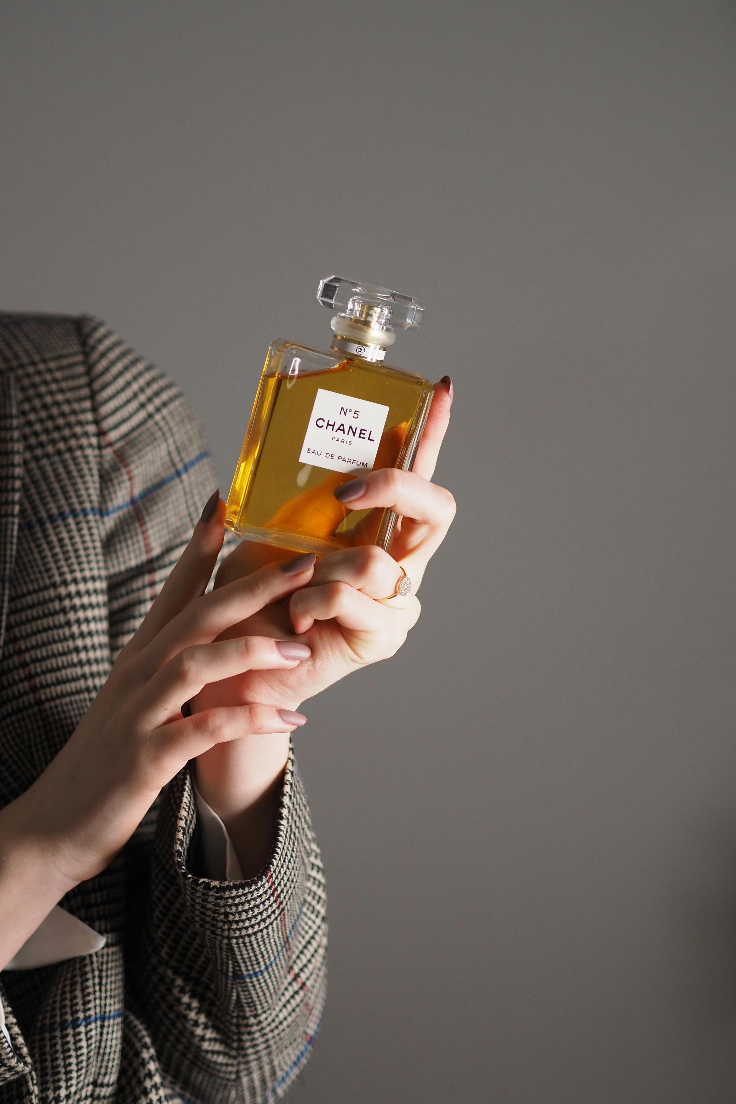 Hands Holding a Bottle of Coco Chanel Perfumes · Free Stock Photo