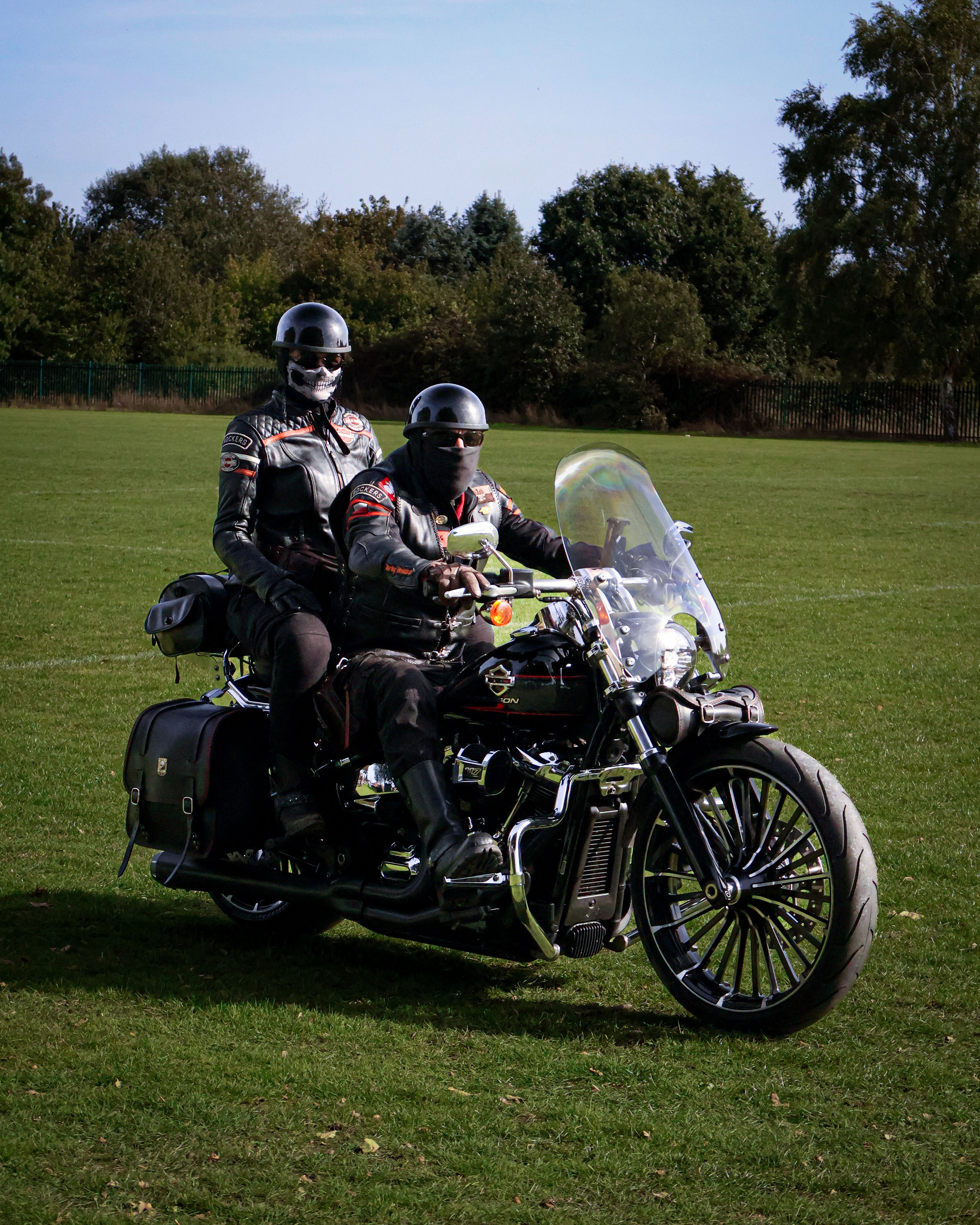 Two people on a motorcycle in a field · Free Stock Photo