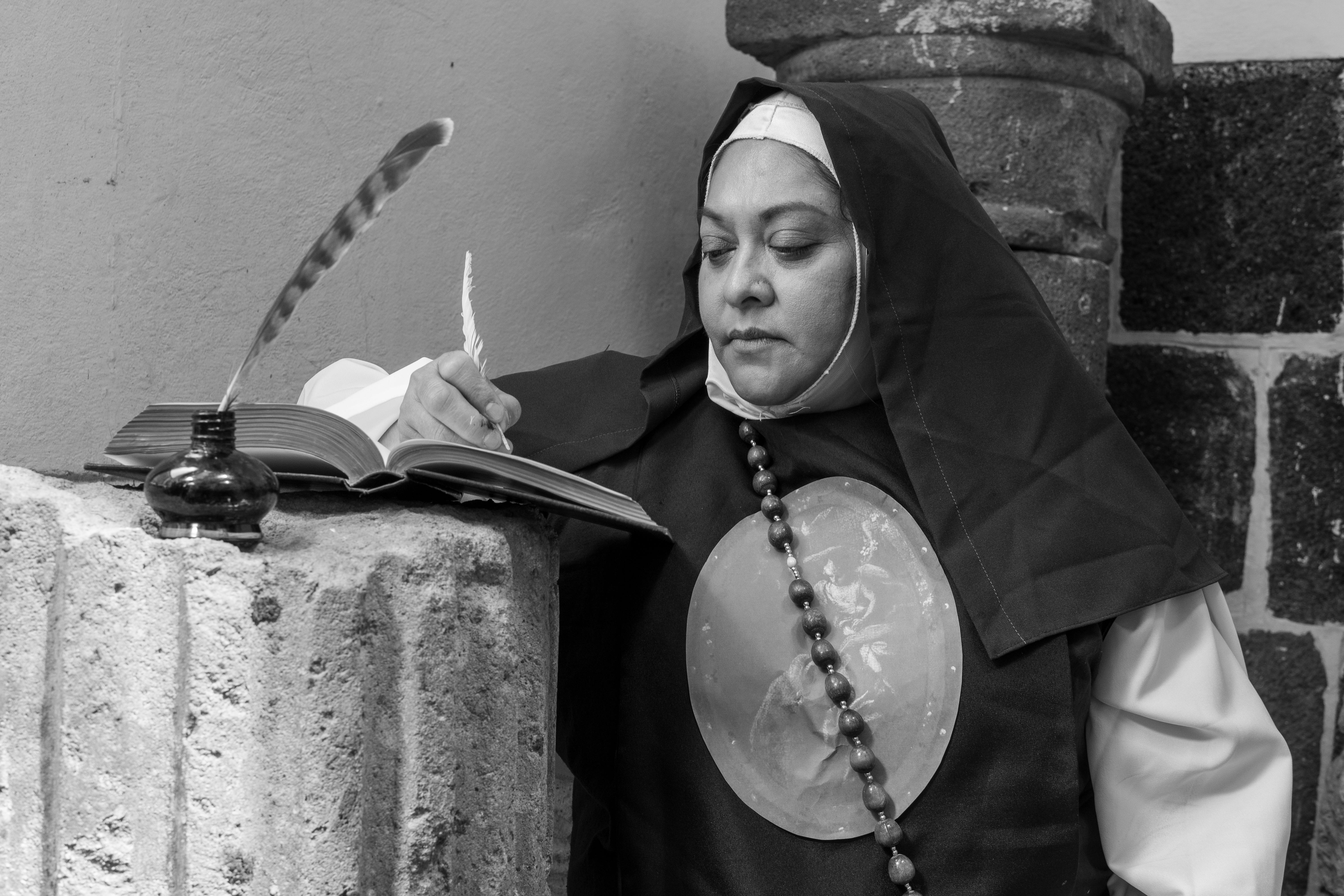 A nun is writing on a book · Free Stock Photo