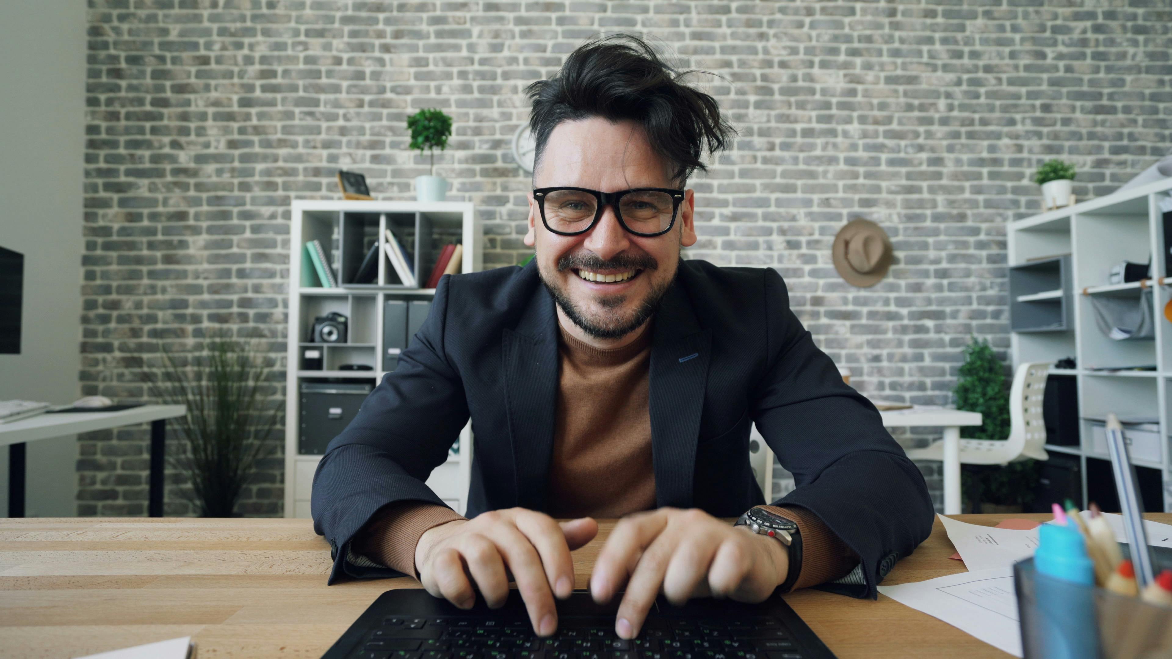 Smiling Man Writing on Laptop · Free Stock Photo