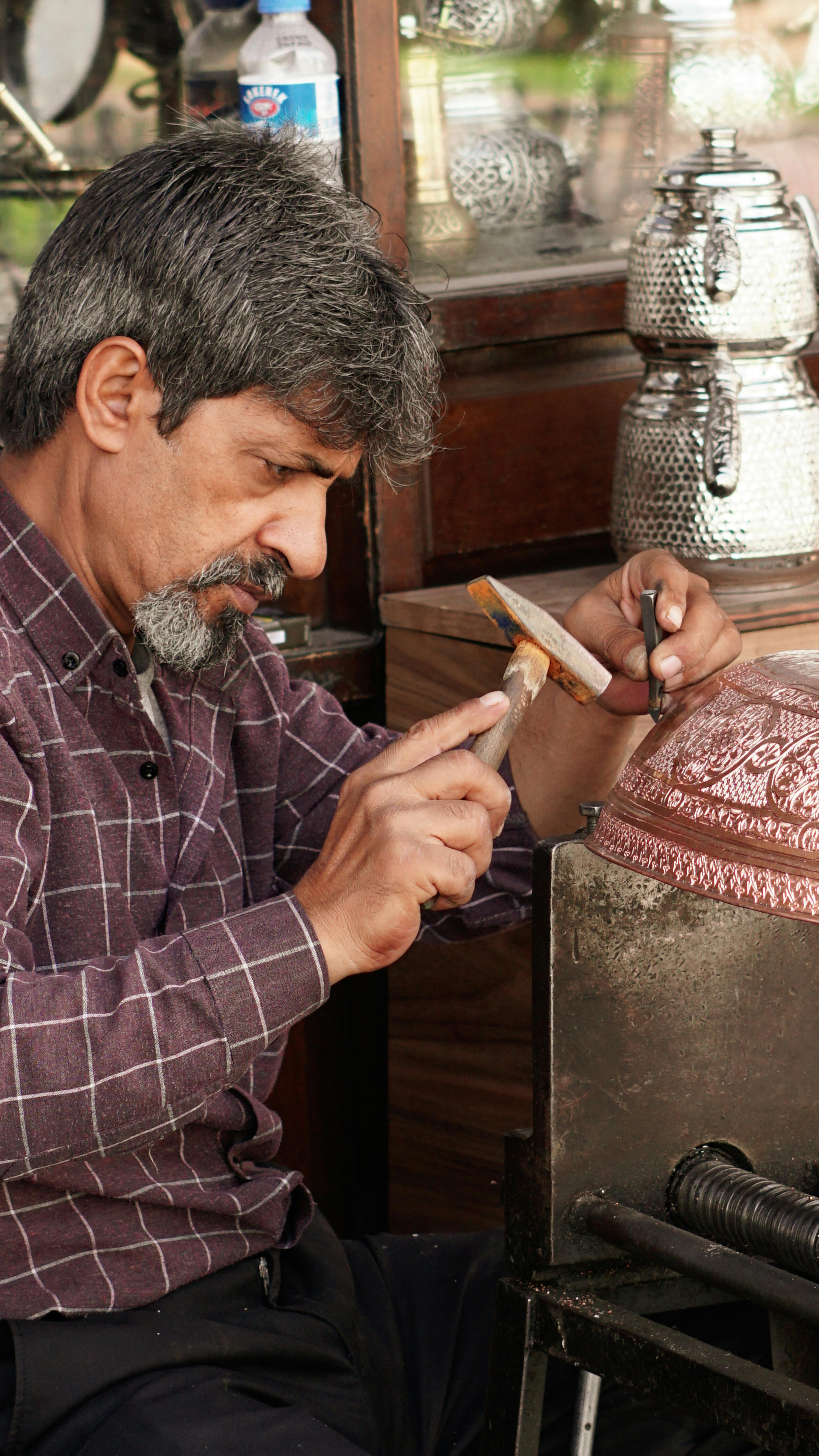 A man making a sculpture in a workshop · Free Stock Photo