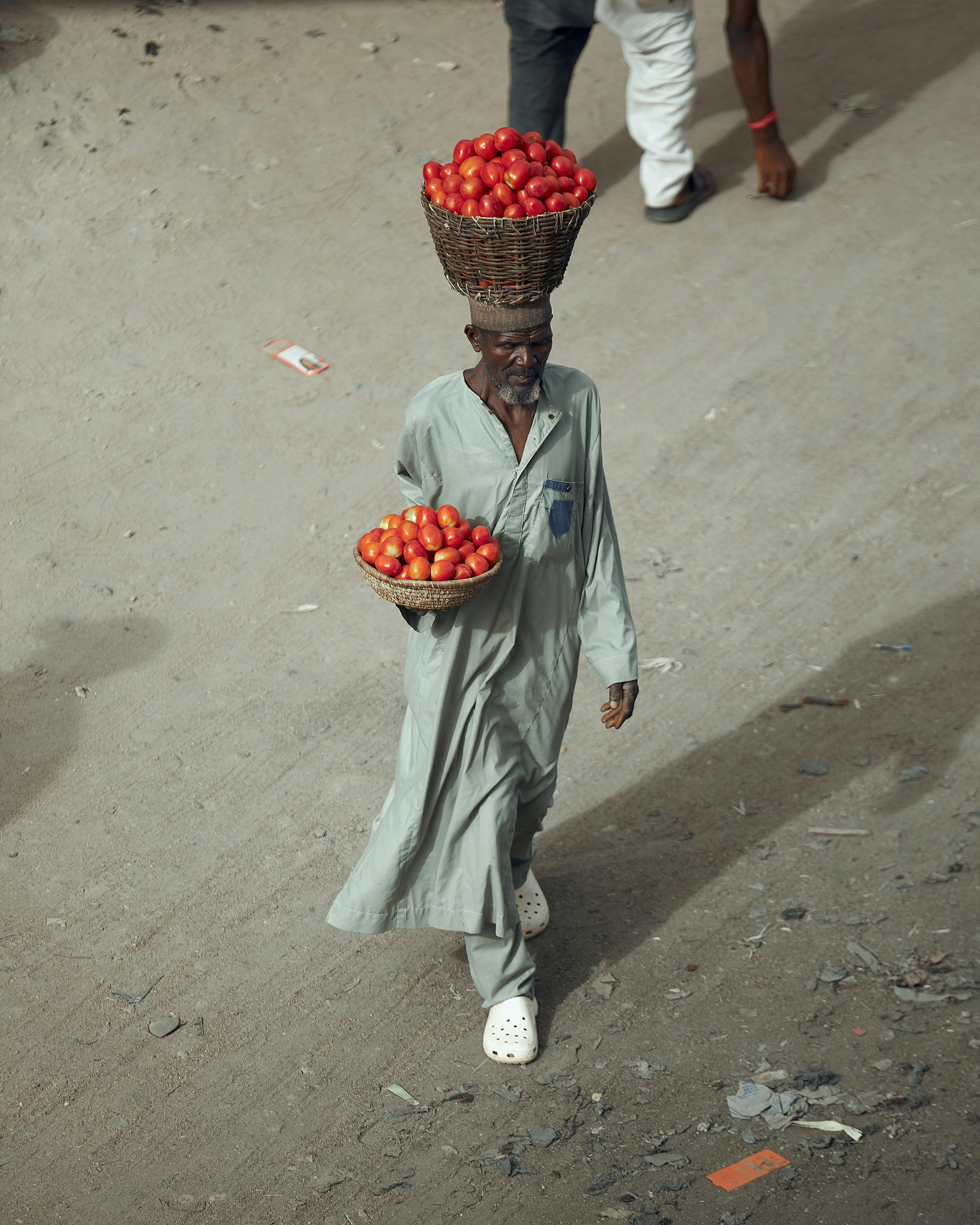 Man Carrying Baskets of Fruit in Village · Free Stock Photo