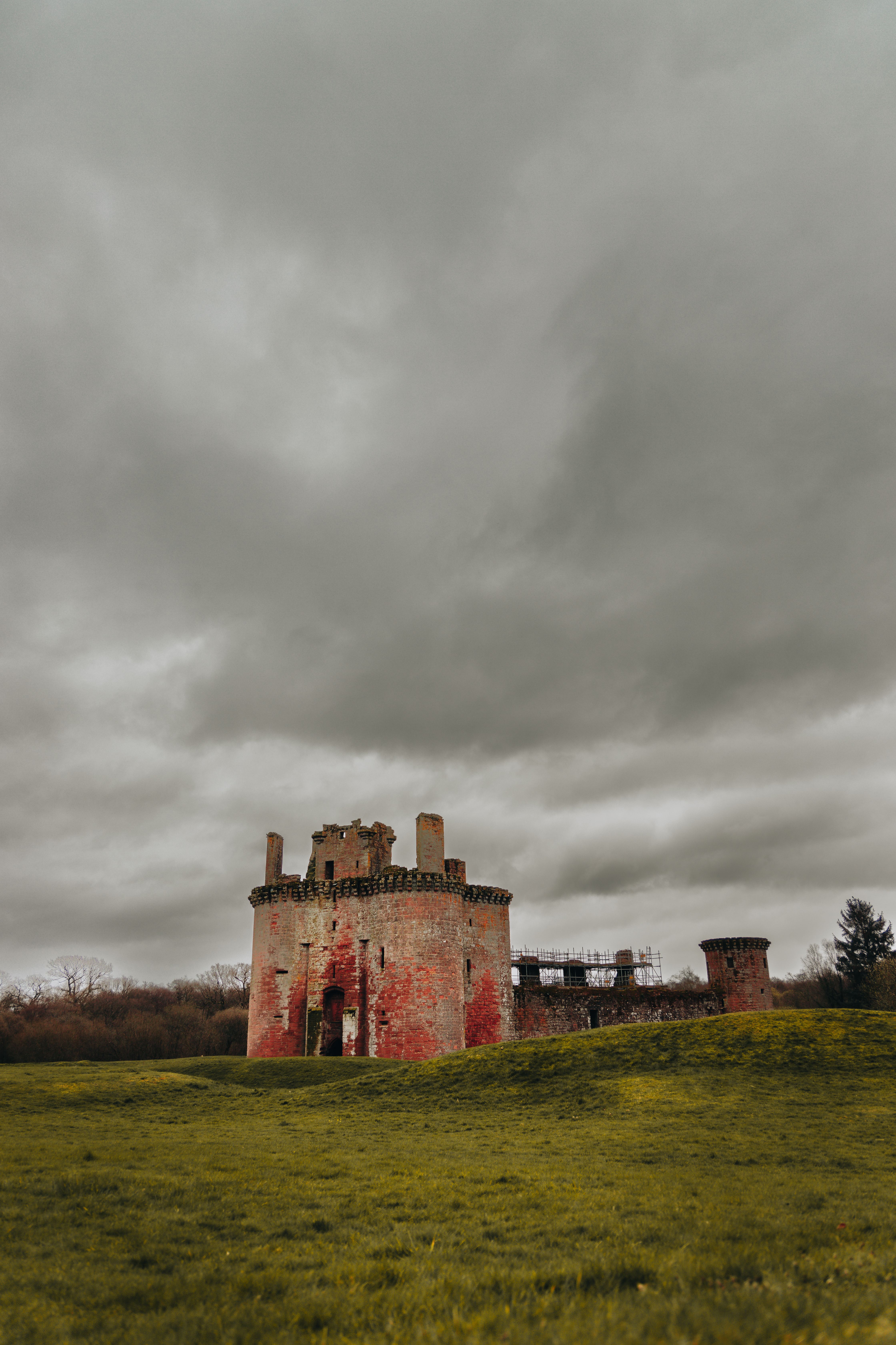 A red brick building sits on a grassy field · Free Stock Photo