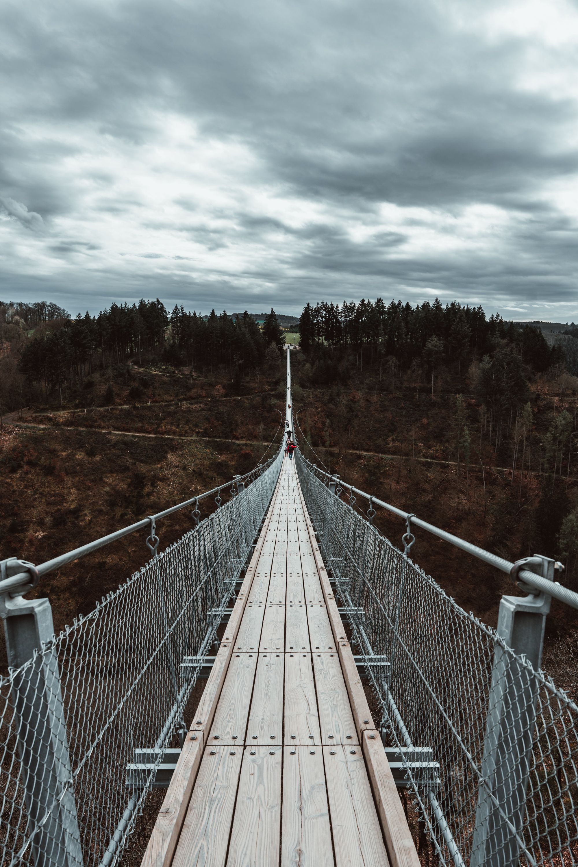 Person Walking Down a Bridge · Free Stock Photo