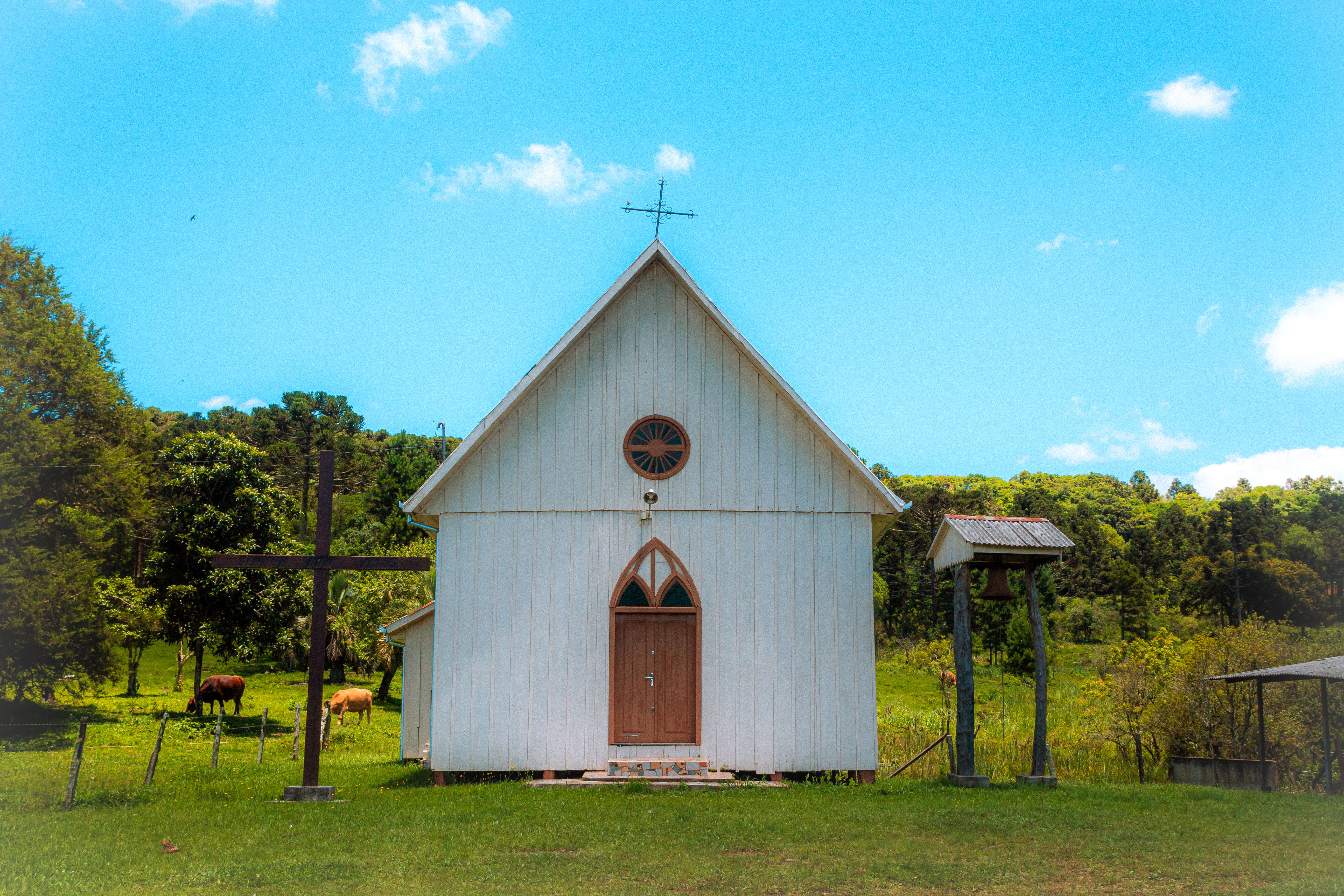 A small white church with a cross on the roof · Free Stock Photo